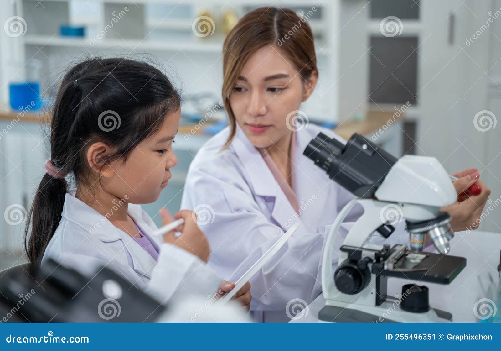 Asian Kid Learning with Scientist in the Laboratory. Physical ...