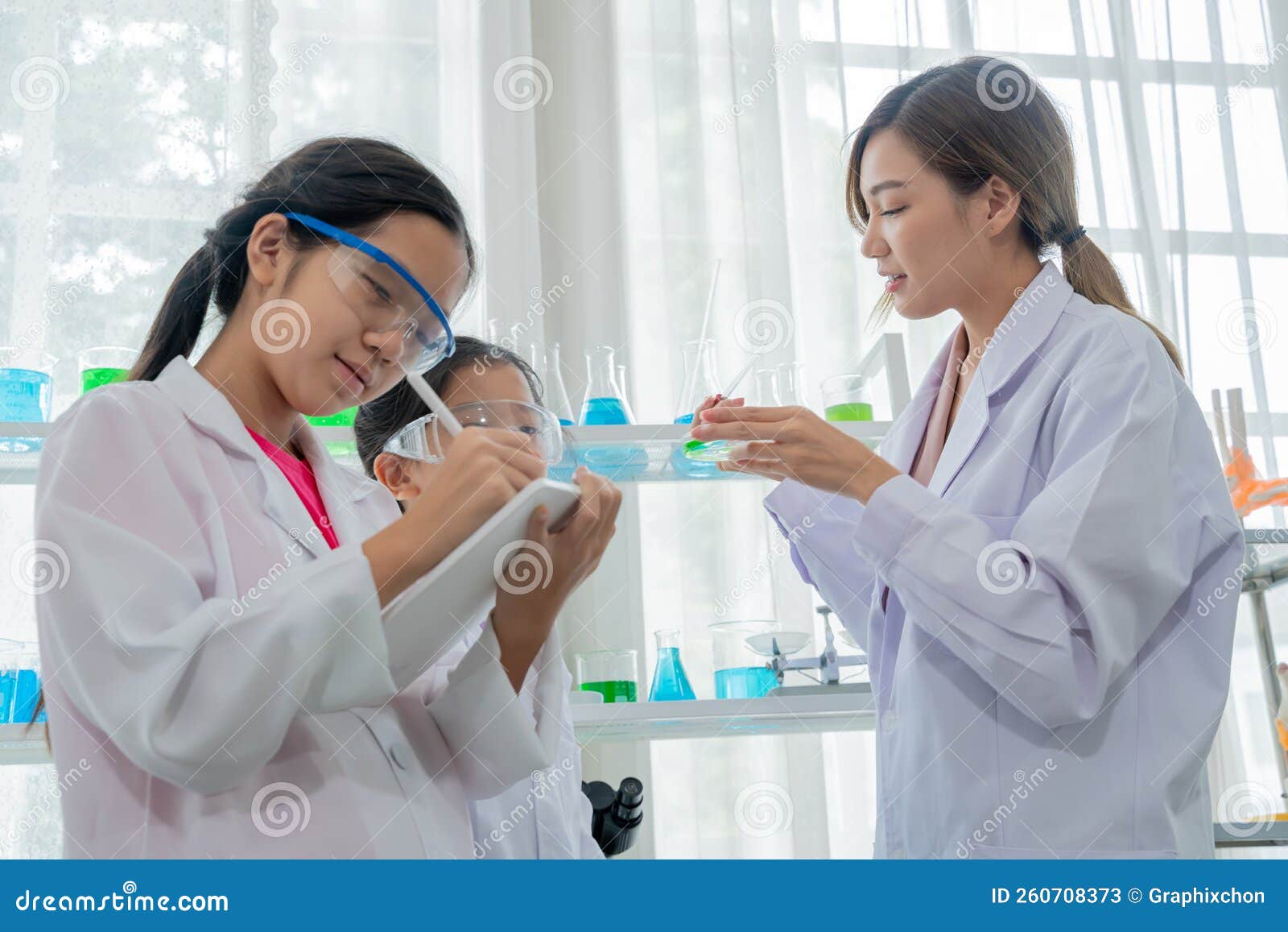 Asian Kid Learning with Scientist in the Laboratory. Physical ...