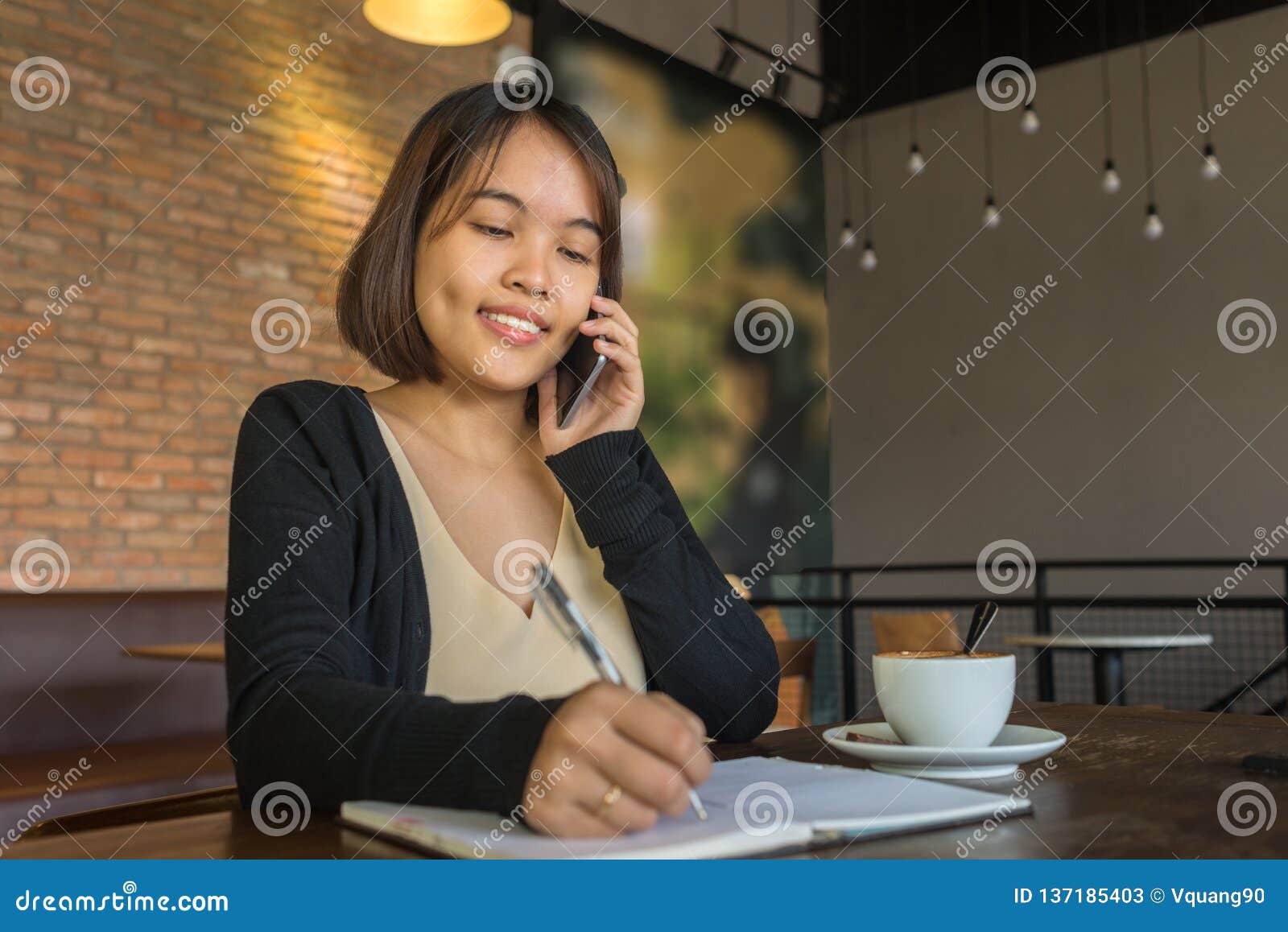 Asian Lady Write Notes, Answer Phone Call in the Coffee Shop Stock ...