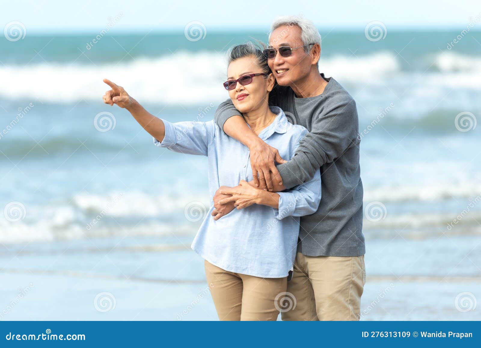 Asian Lifestyle Senior Couple Walking Chill And Pointing On The Beach