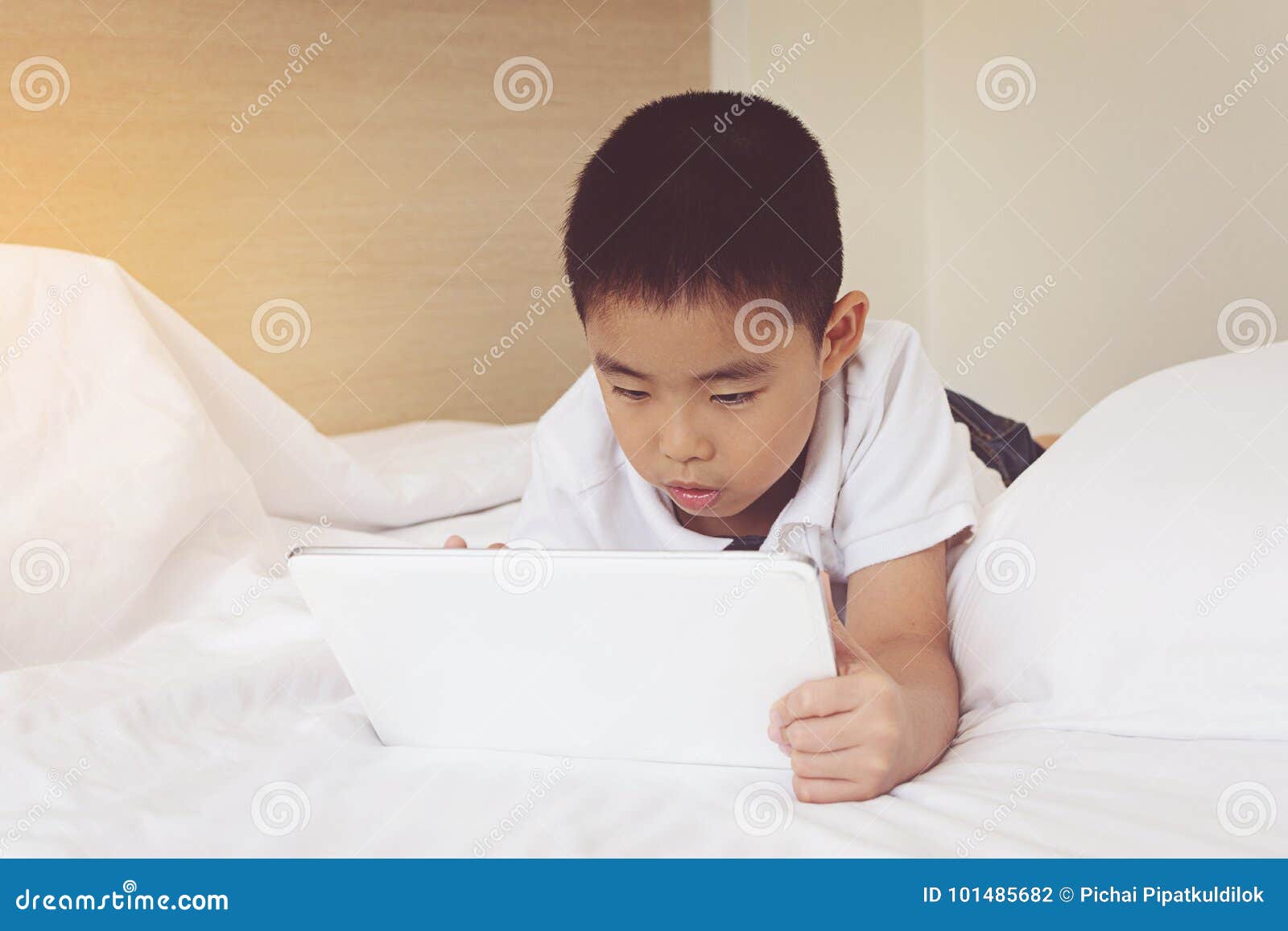 Asian Little Boy Using Tablet Computer in Bed. Stock Photo - Image of ...