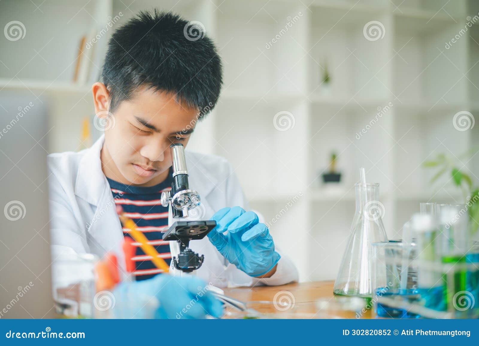 Asian Male Science Students Looking through a Microscope and Tests of ...