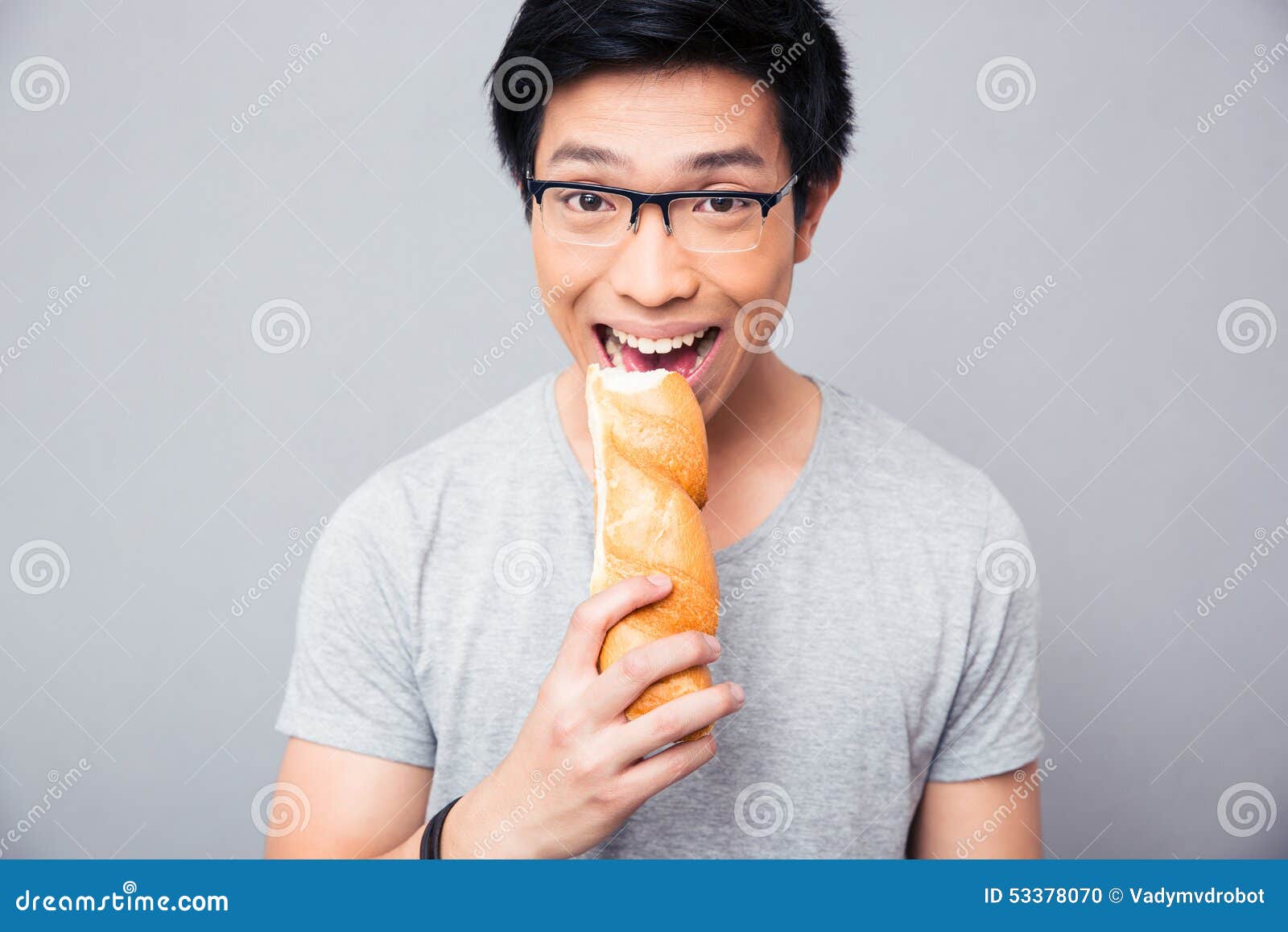 Asian Man Biting Bread Over Gray Background Stock Photo - Image of ...