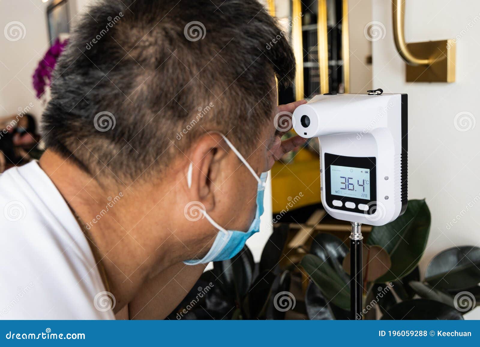 Asian Man Checking Forehead Temperature Using Infrared Thermometer ...