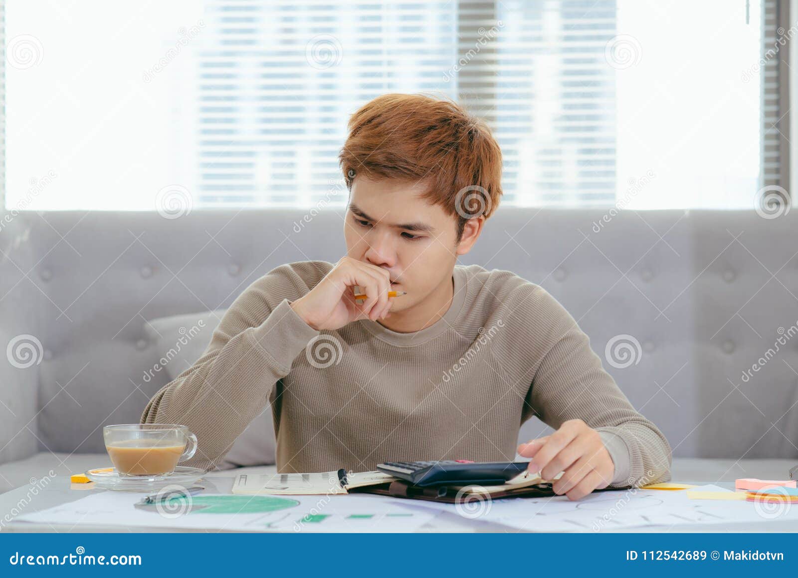 Asian Man Doing Finances and Calculate about Cost at Home Office Stock ...