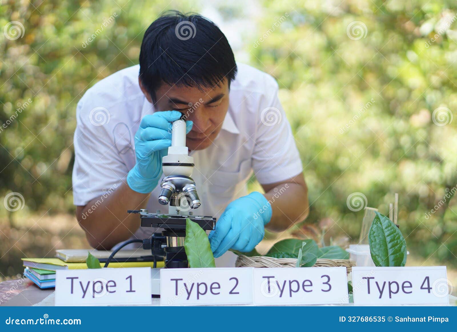 Asian Man is Doing Science Experiment, Using Microscope To Inspect ...