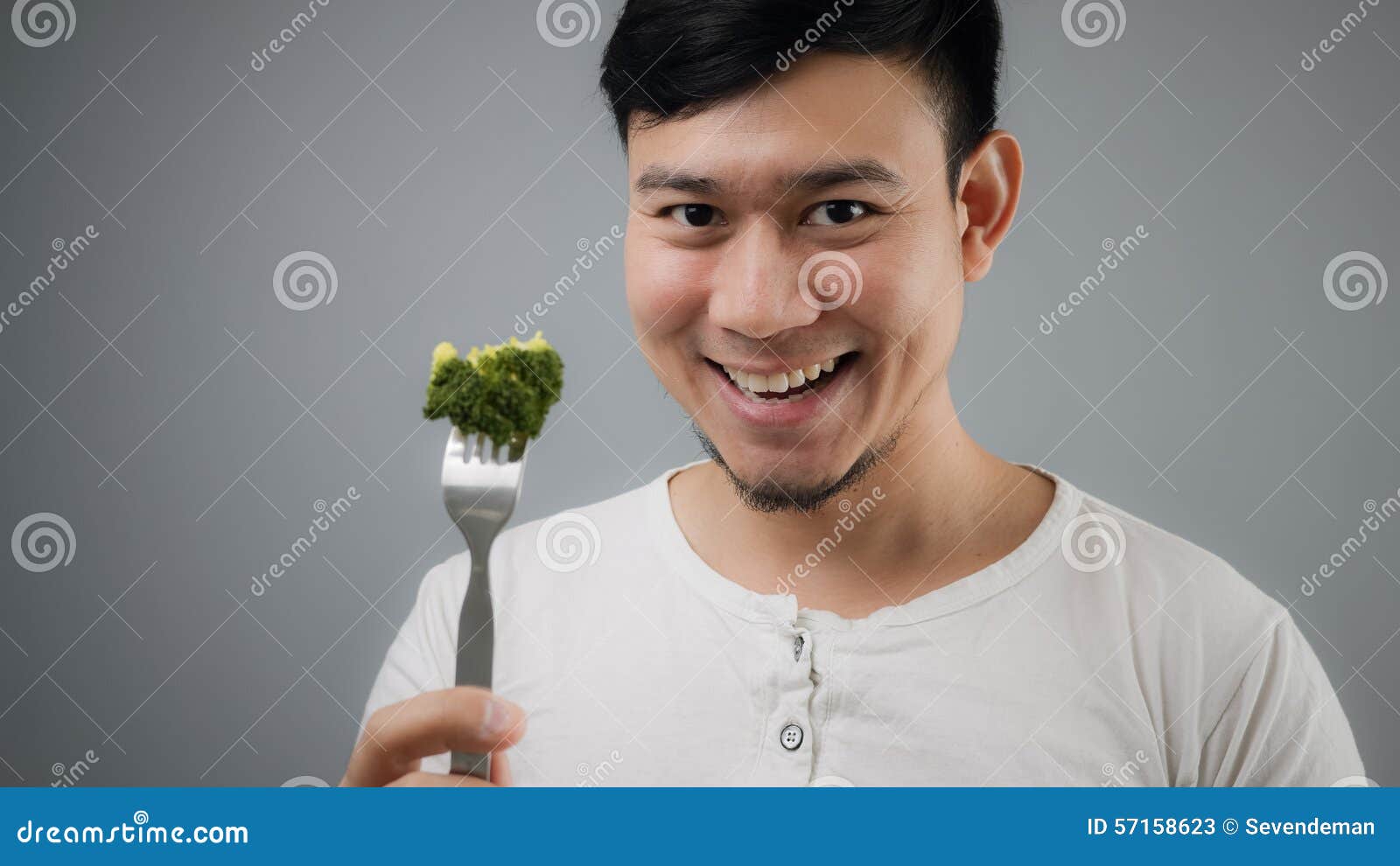 An Asian Man Eats Broccoli. Stock Image - Image of food, male: 57158623