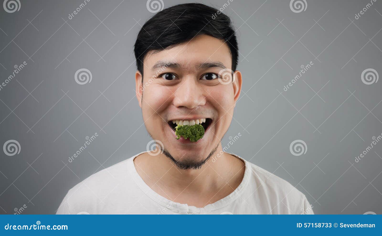 An Asian Man Eats Broccoli. Stock Image - Image of holding, food: 57158733