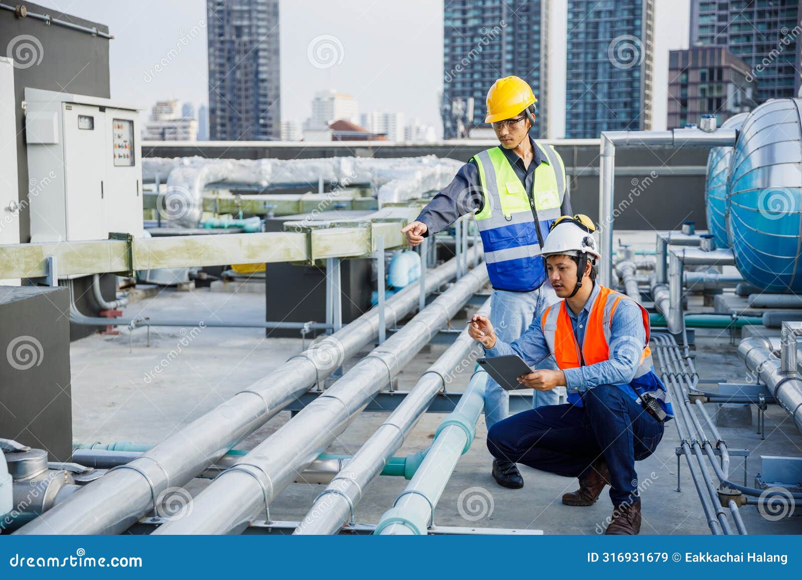 Asian Man Engineer Holding Tablet Working at Rooftop Building Construction. Male Technician ...
