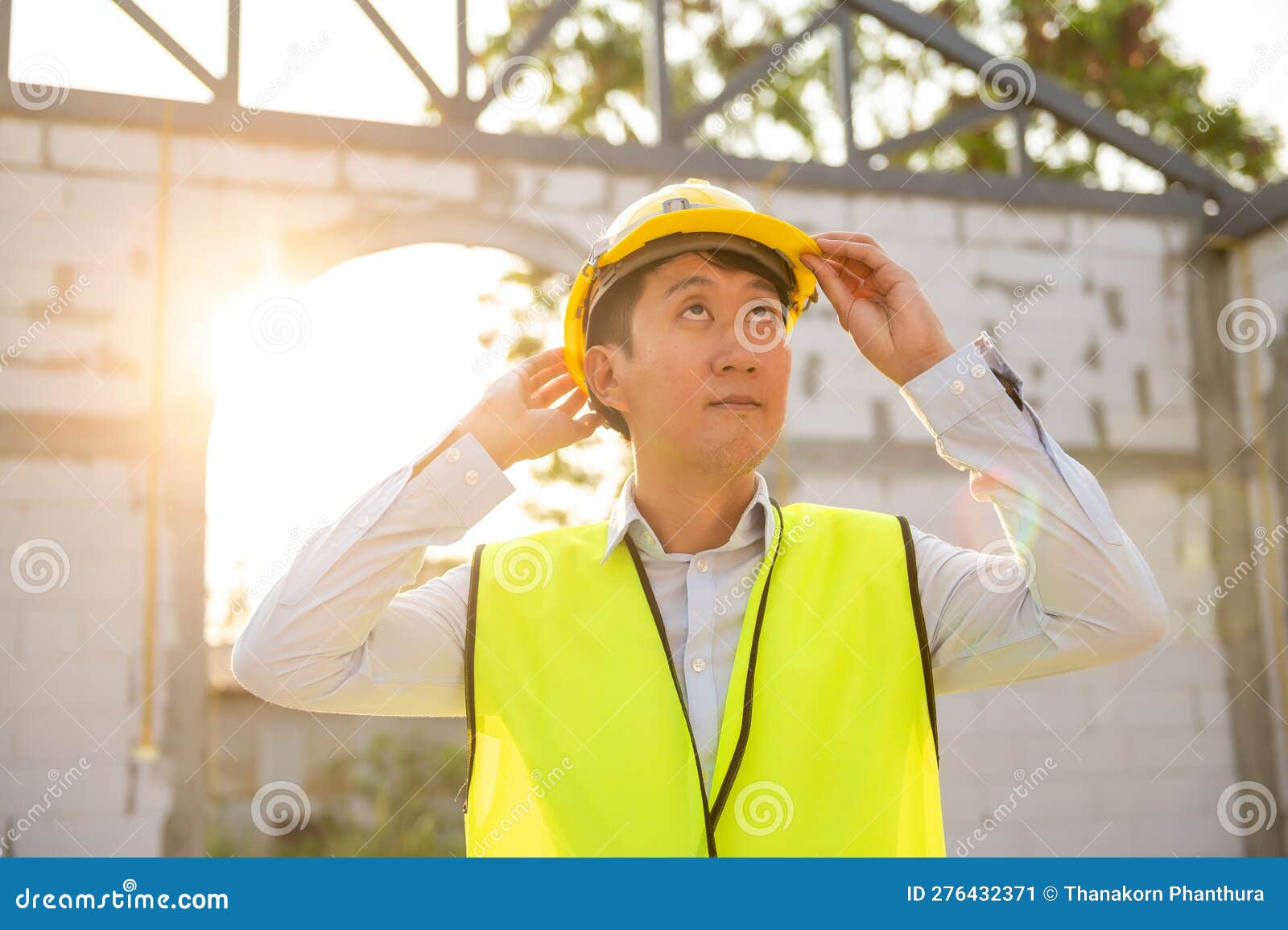Asian Man Engineer is Putting a Protective Helmet on His Head Stock ...