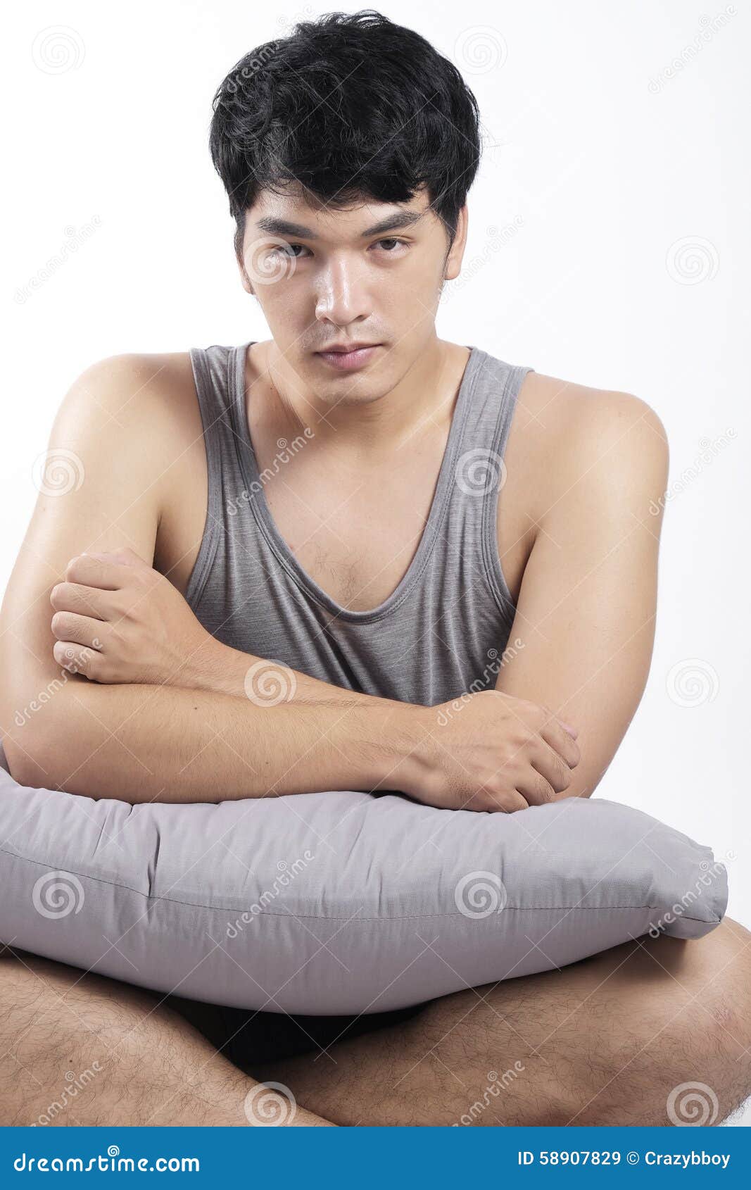 Asian Man In Grey Pajamas Sitting And Holding The Pillow Stock Image