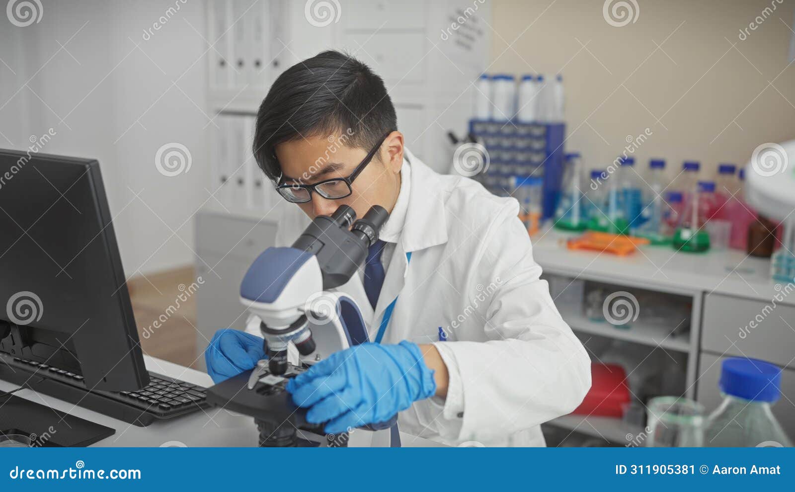 Asian Man in Lab Coat Using Microscope in a Modern Laboratory Indoors ...