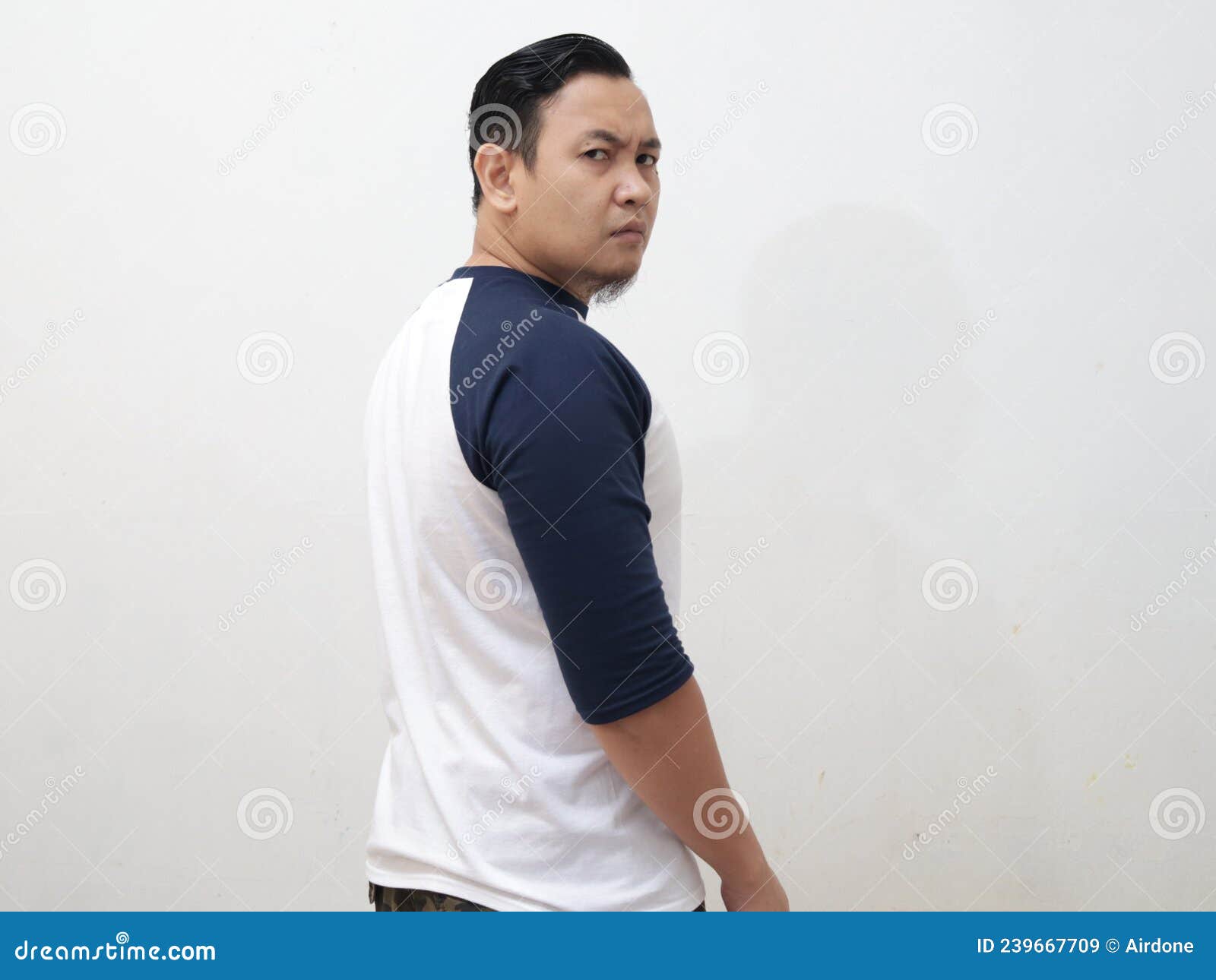 Asian Man Looking Back Over His Shoulder with Suspicious Unhappy ...