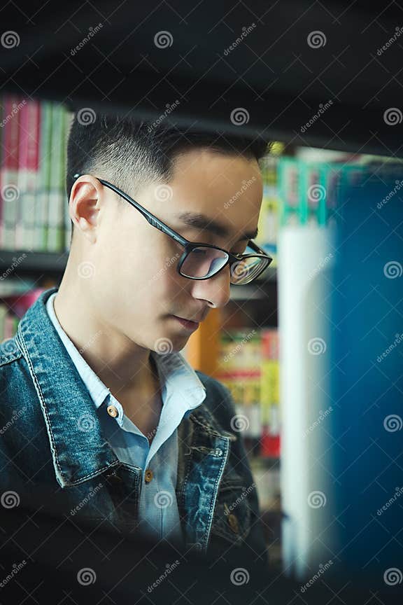 An Asian Man Reading in a Library Stock Photo - Image of libraries ...