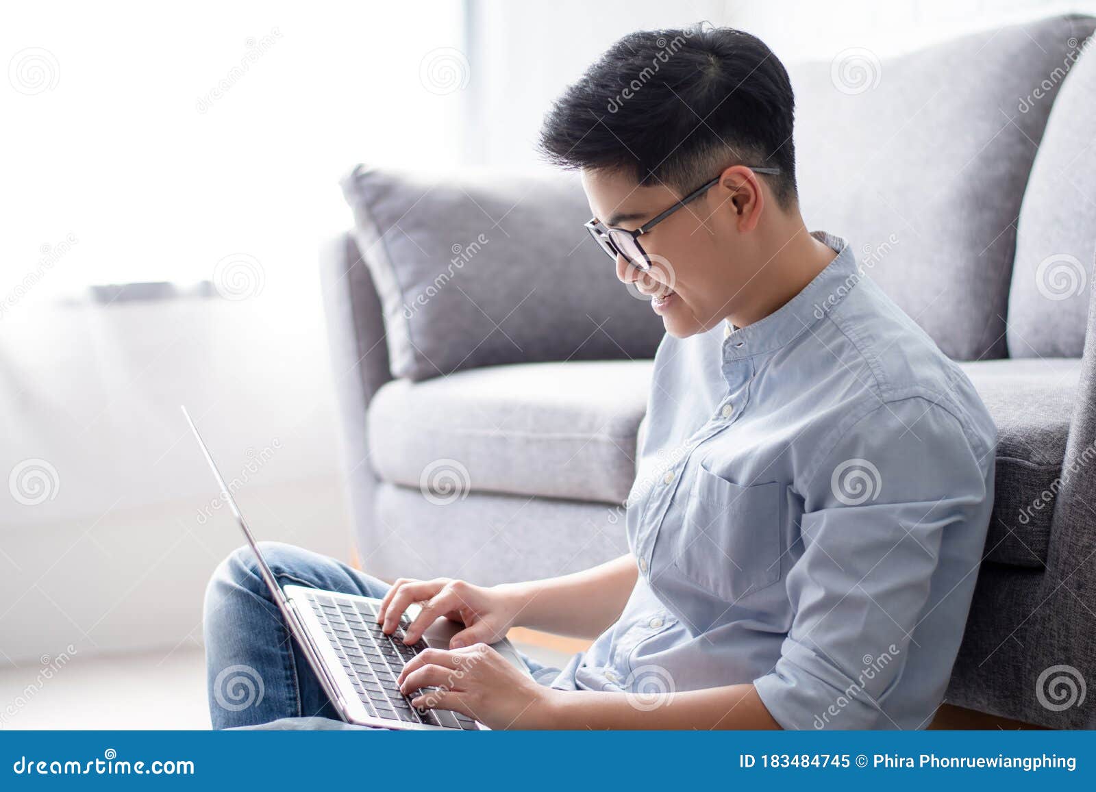 Asian Man Sitting on the Floor and Working on a Computer Laptop at Home ...
