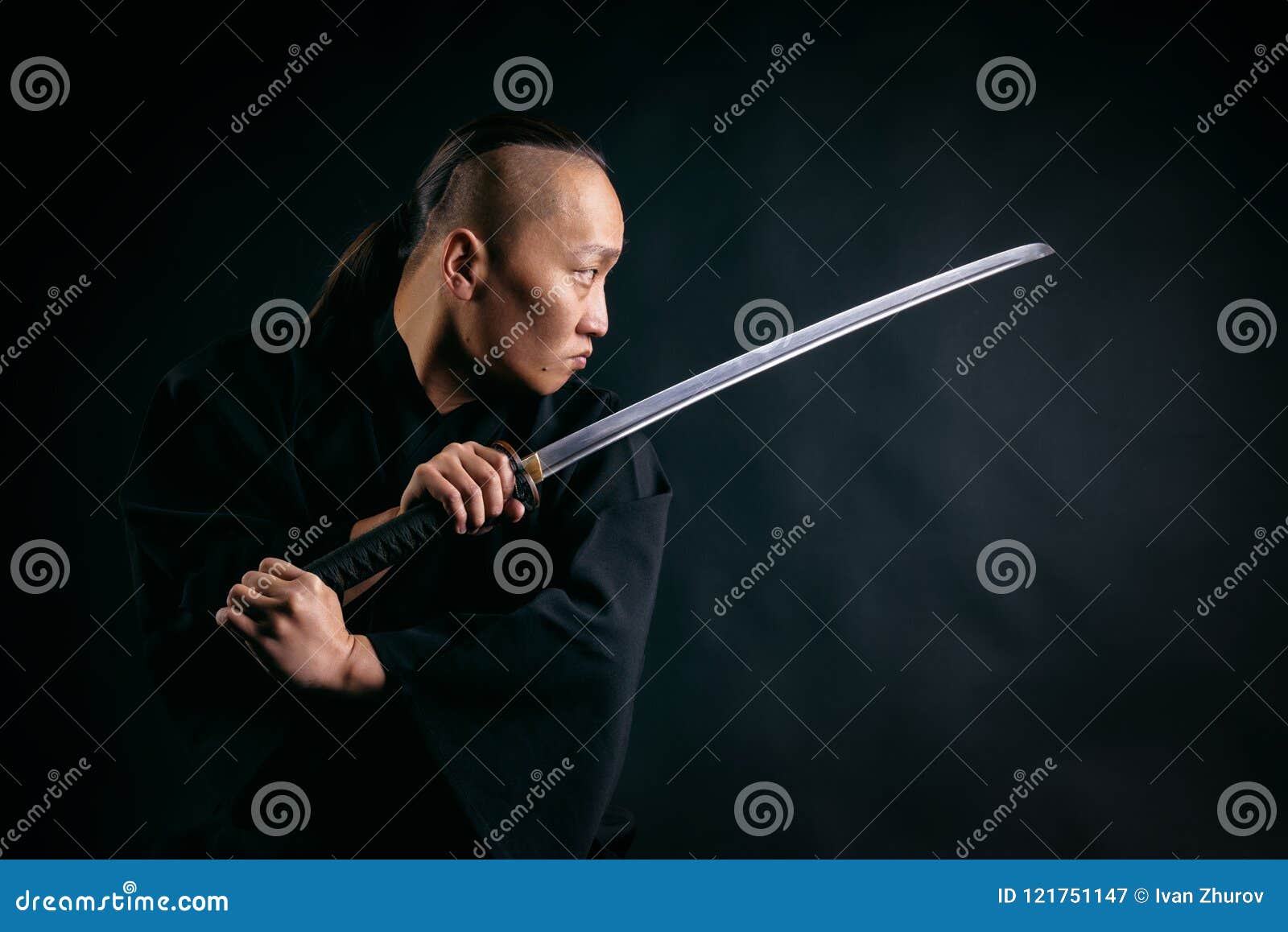 Asian Man With A Sword In His Hands In A Black Robe Against A Black ...
