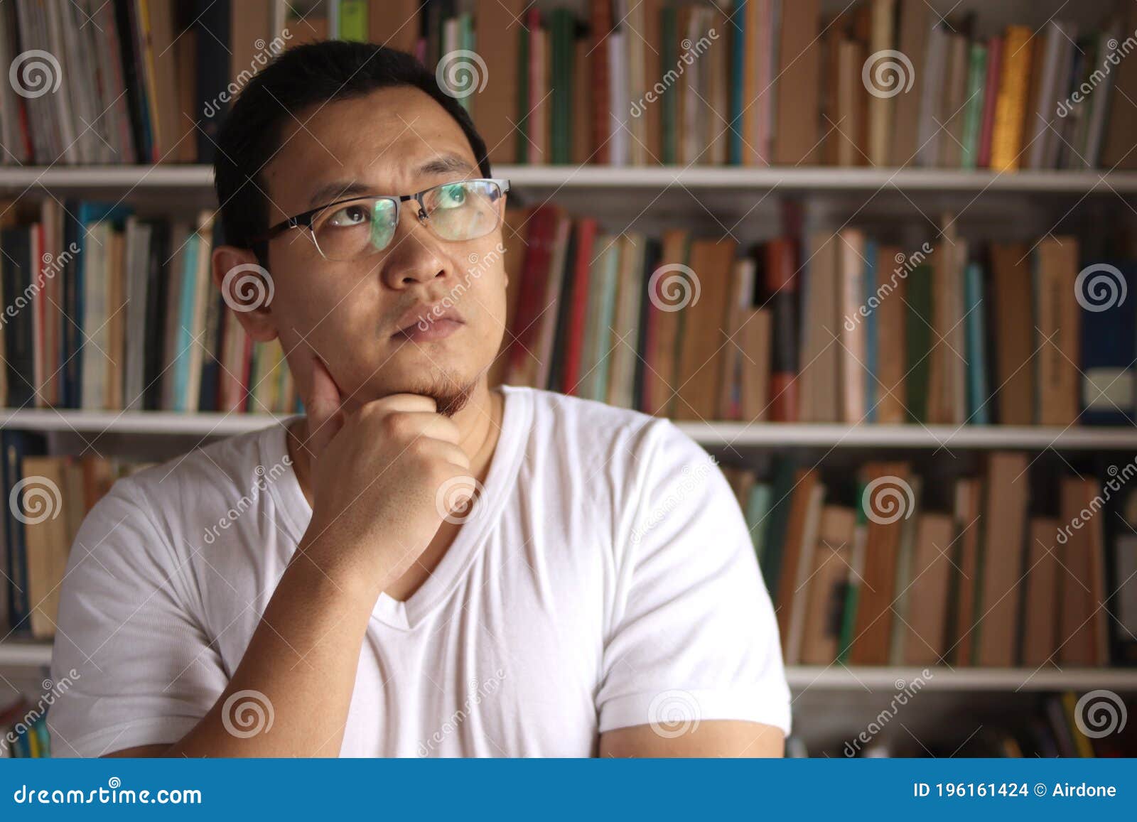 Asian Man Thinking while Standing in Front of Bookshelf, Education ...