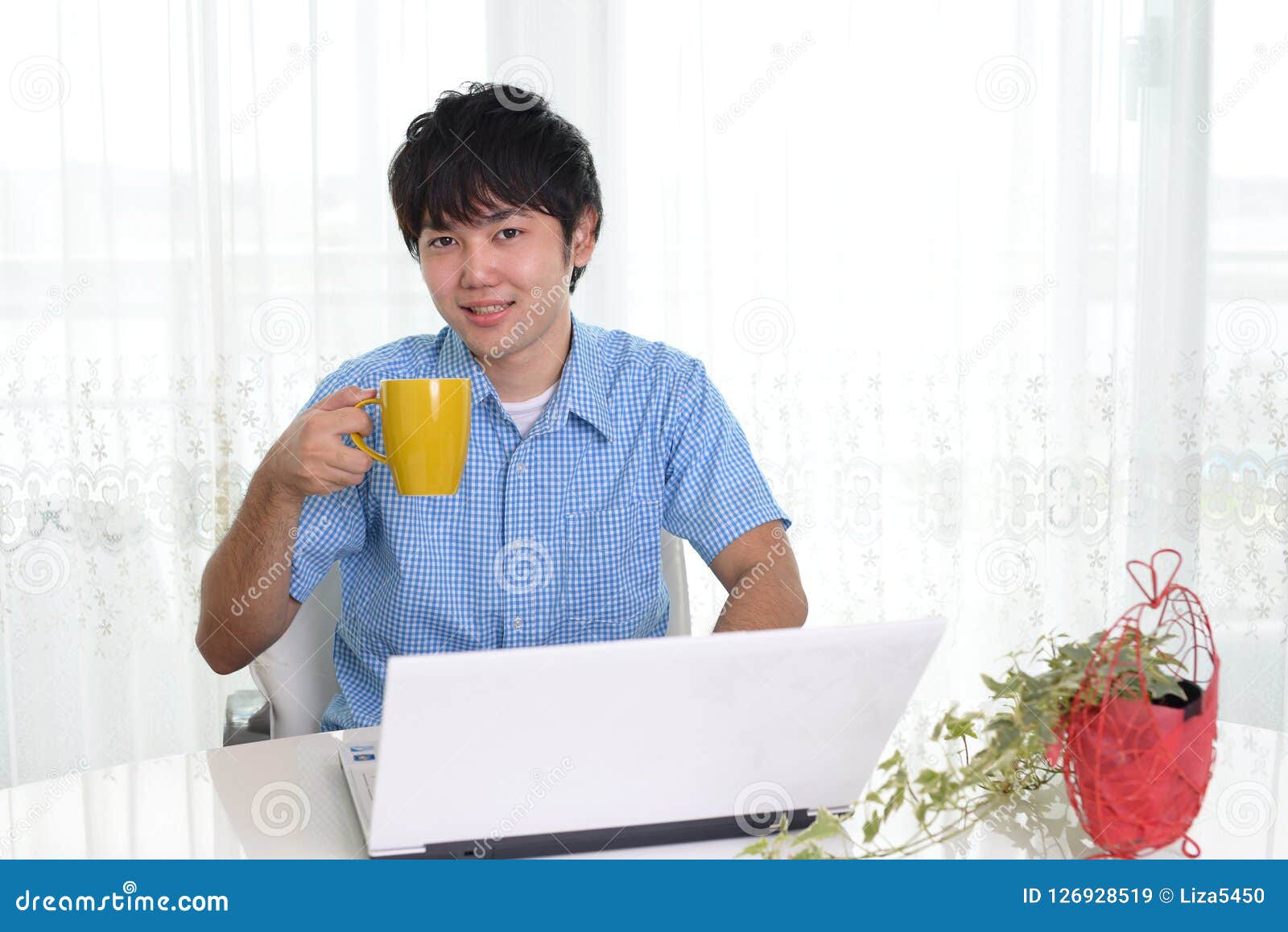 Asian man using a laptop stock image. Image of cozy - 126928519