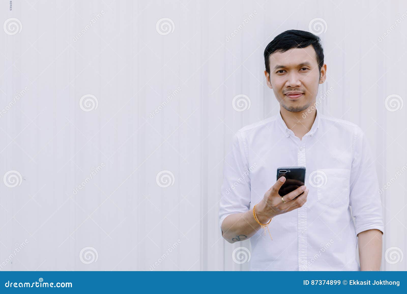 Asian Man Using a Mobile Phone Smile with White Walls Stock Image ...