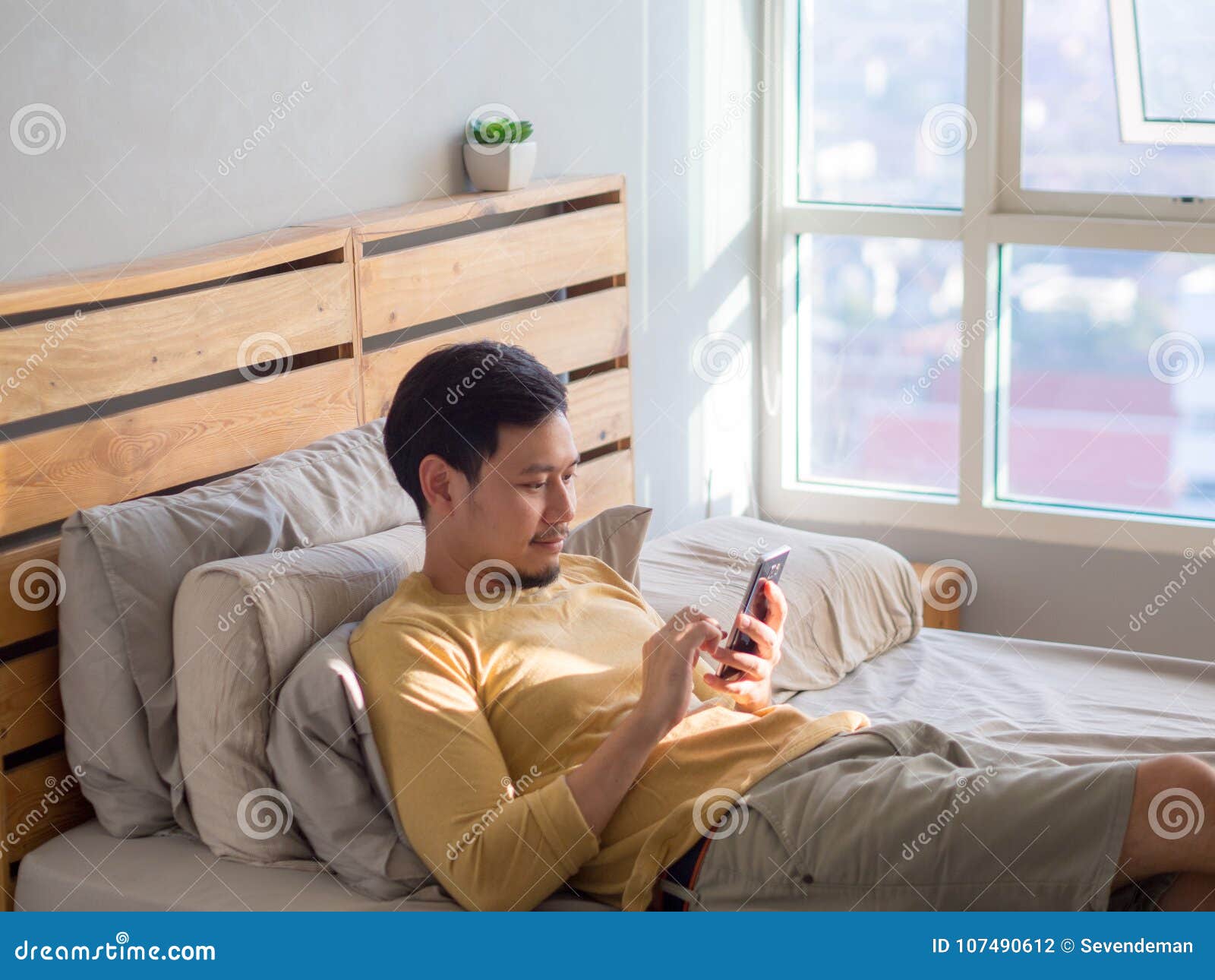 Man Using Smartphone in His Bed in the Morning. Stock Photo - Image of ...