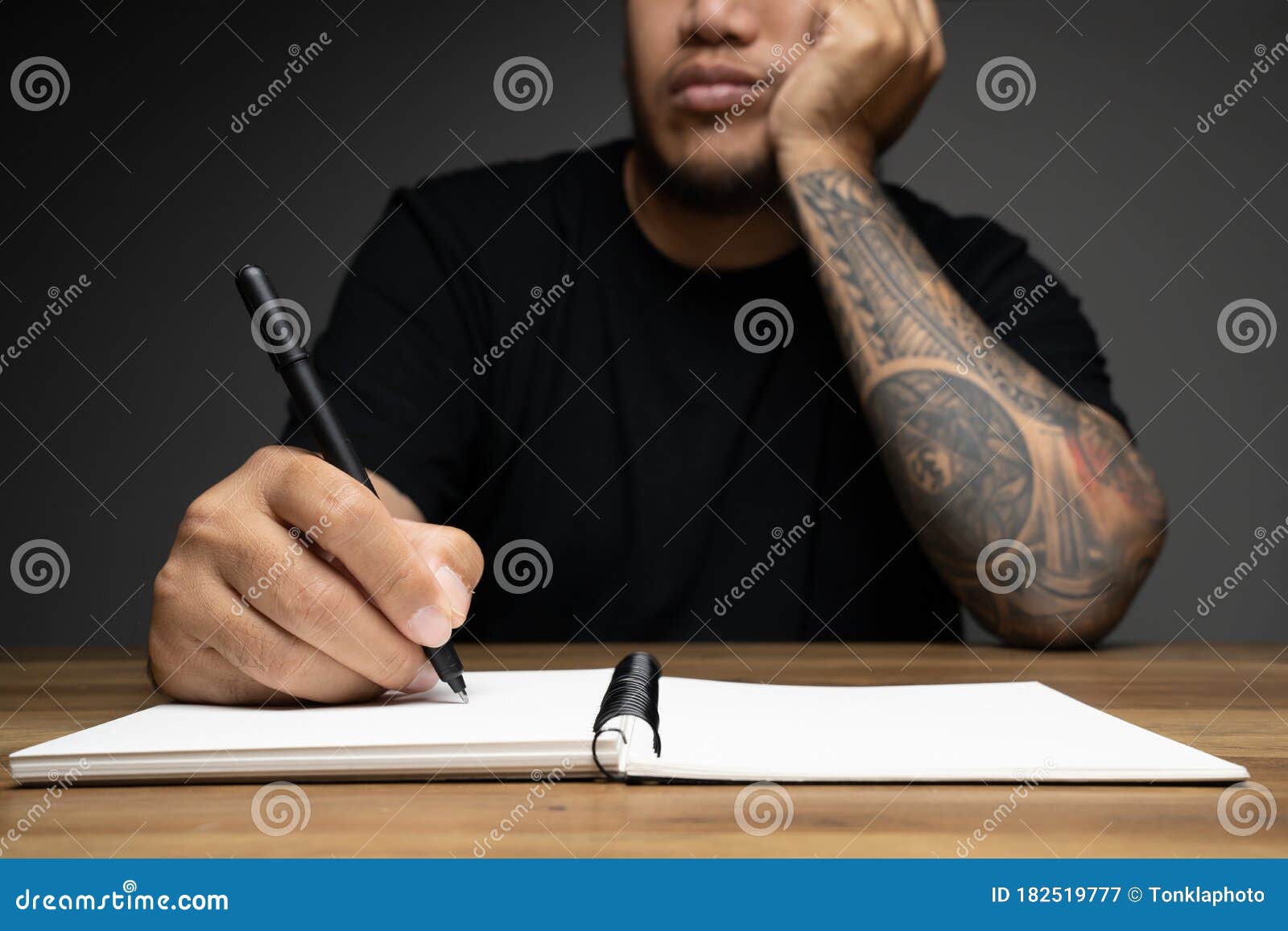 Asian Man Writing on a Note Book with Boring Face on Wooden Table ...