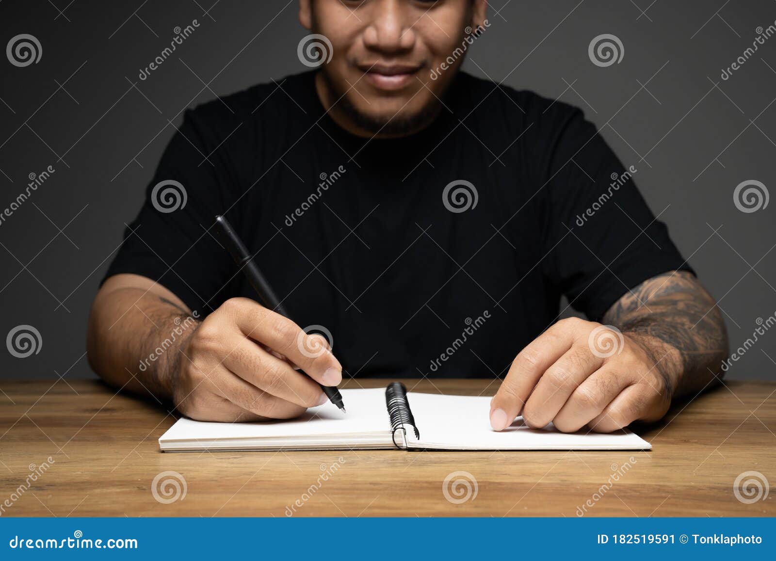 Asian Man Writing on a Note Book with Smile Face on Wooden Table ...