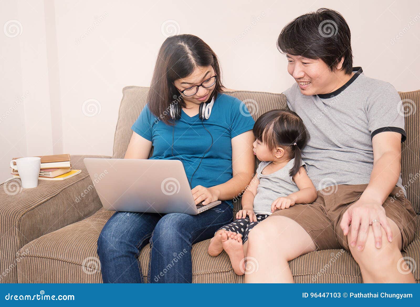 Asian Mom And Dad Using Computer With Their Daughter Stock Image