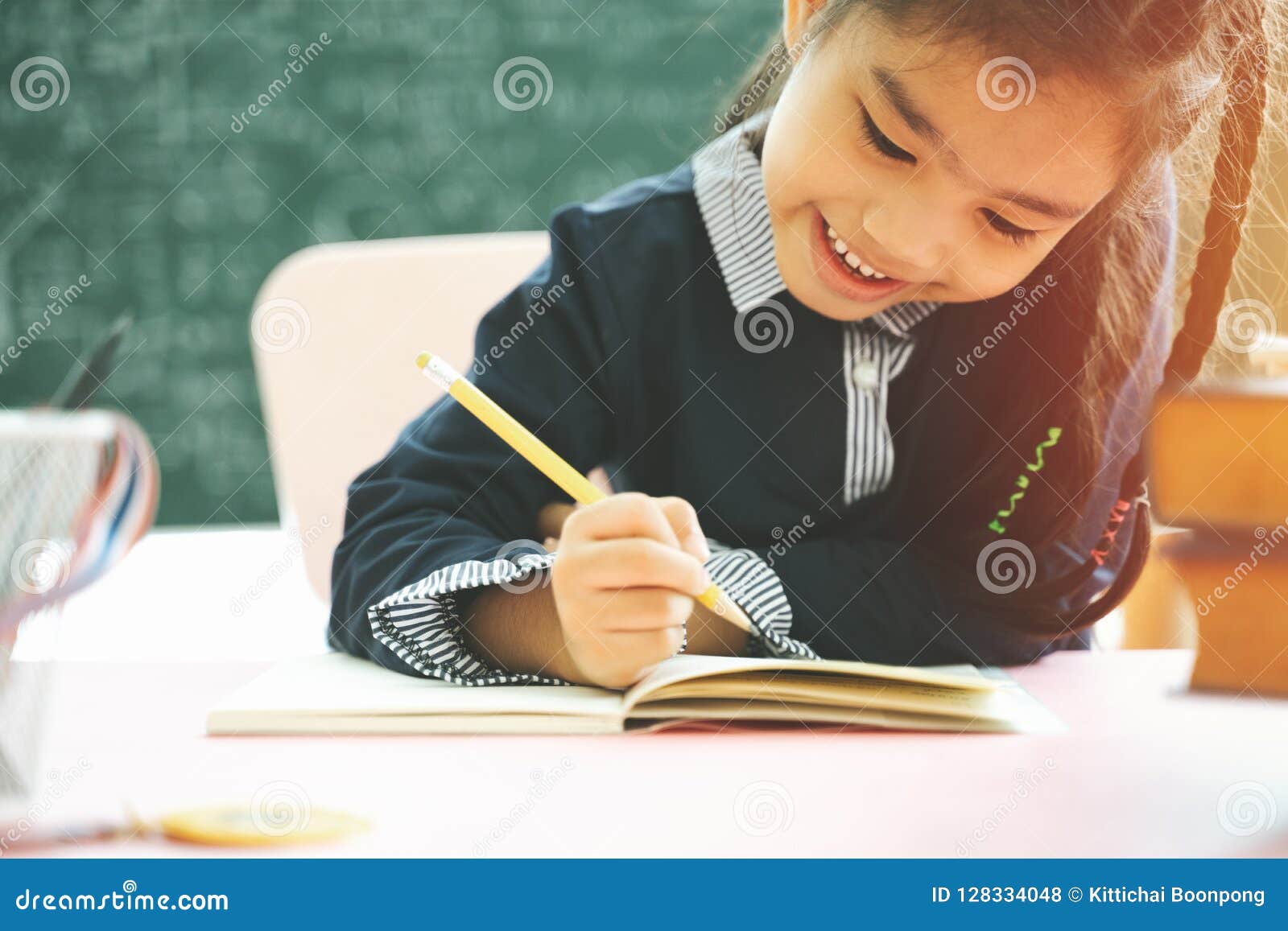 Asian Primary School Student Studying Homework in Classroom. Stock ...