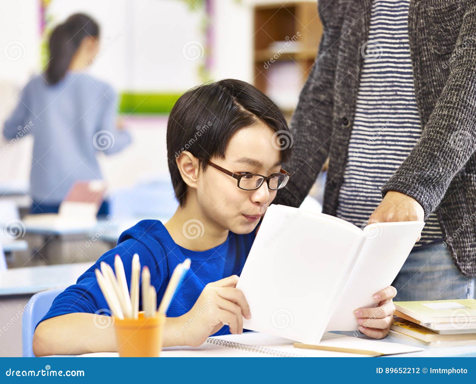 Asian Pupil Getting Help from Teacher Stock Photo - Image of desk ...