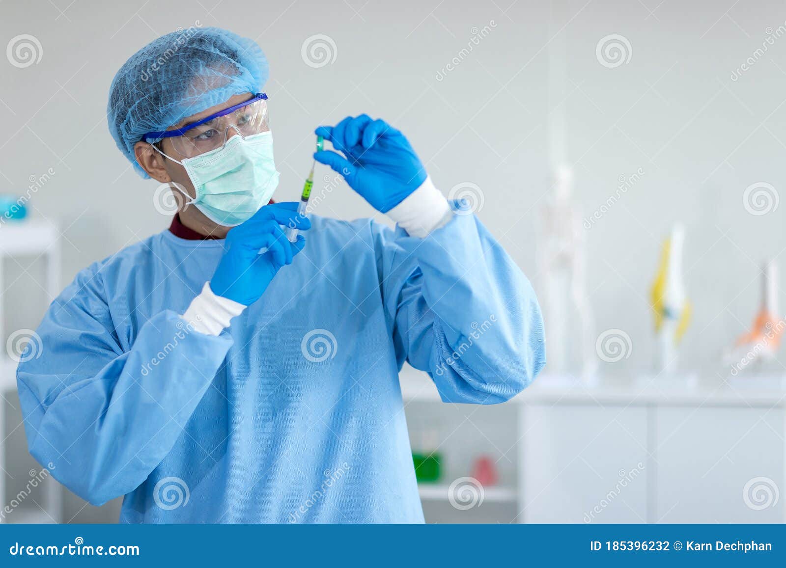 Asian Scientists Wear Protective Clothing while Using a Syringe To Test ... Asian Scientists Wear Protective Clothing while Using a Syringe To Test ...