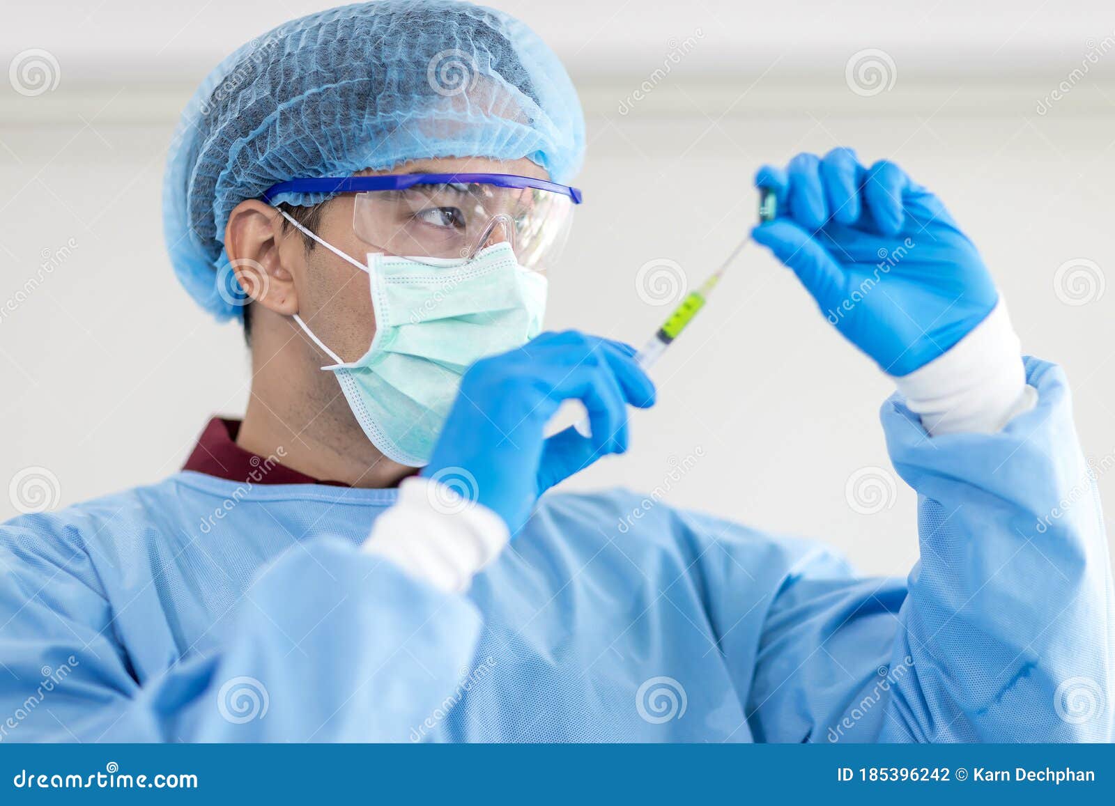 Asian Scientists Wear Protective Clothing while Using a Syringe To Test ... Asian Scientists Wear Protective Clothing while Using a Syringe To Test ...