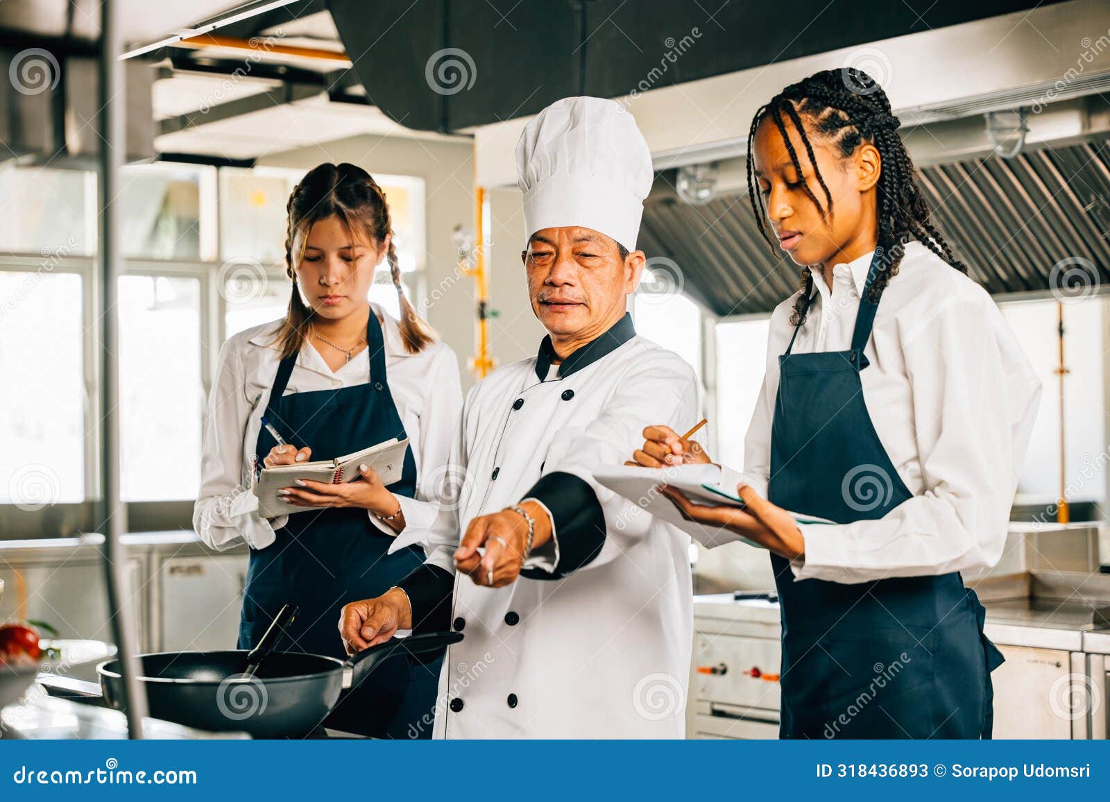 Asian Senior Chef in Uniform Teaches Cooking Techniques To Multiracial ...
