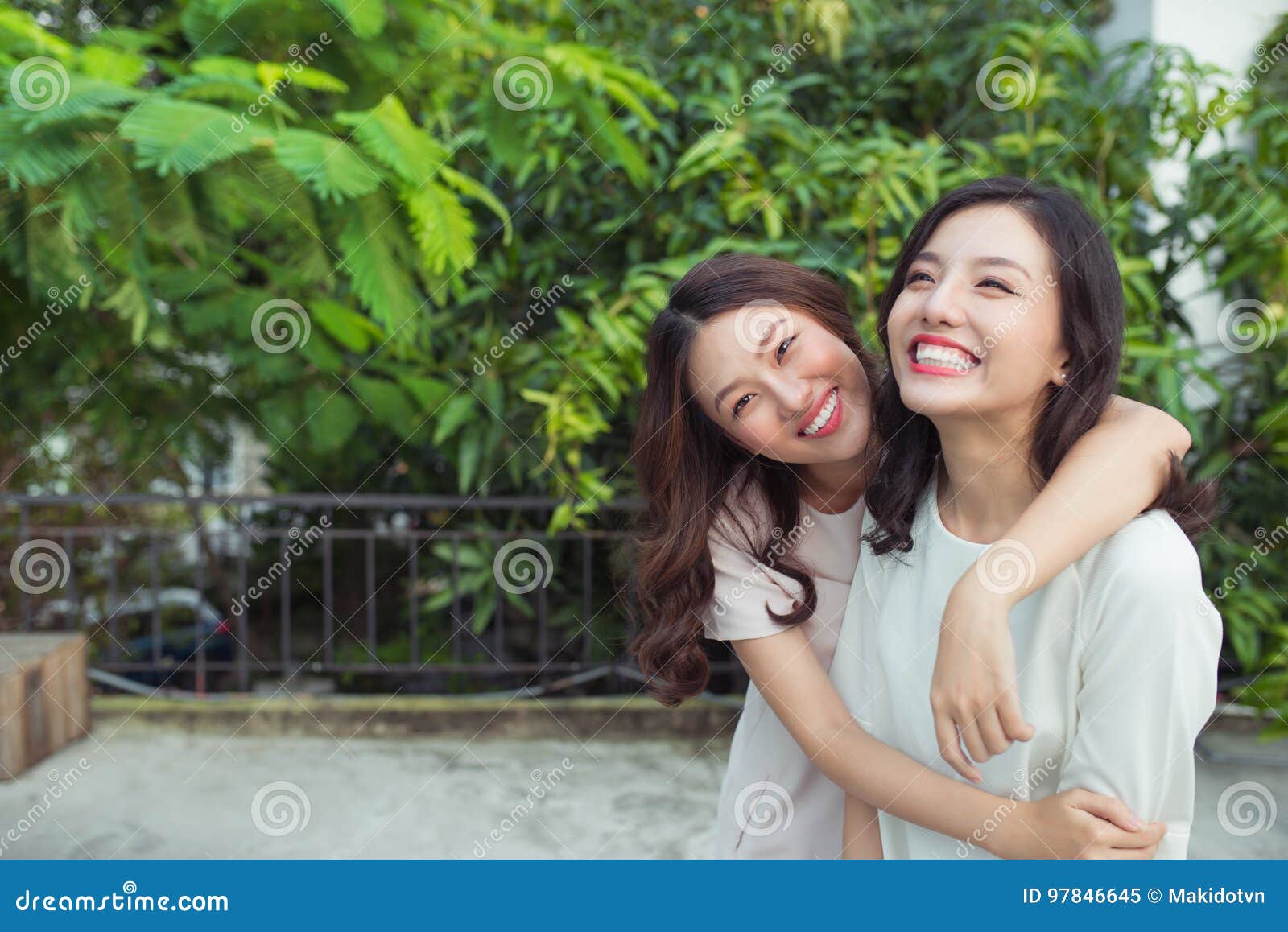 Asian Sisters Hugging and Smiling in the Park. Stock Image - Image of ...