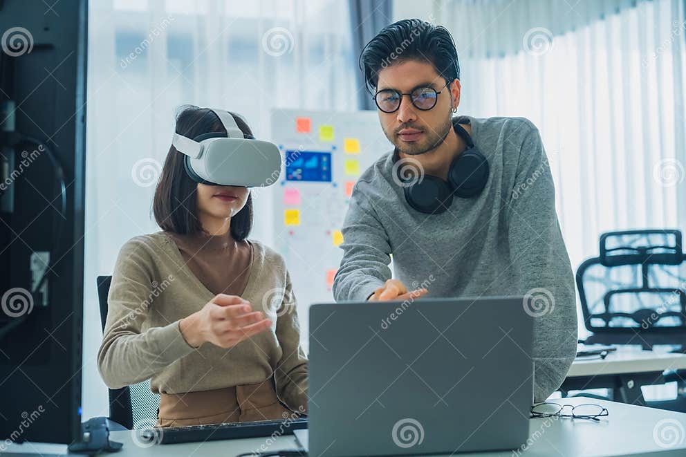 Asian Software Developer Wearing a Virtual Reality Headset Works on a ...