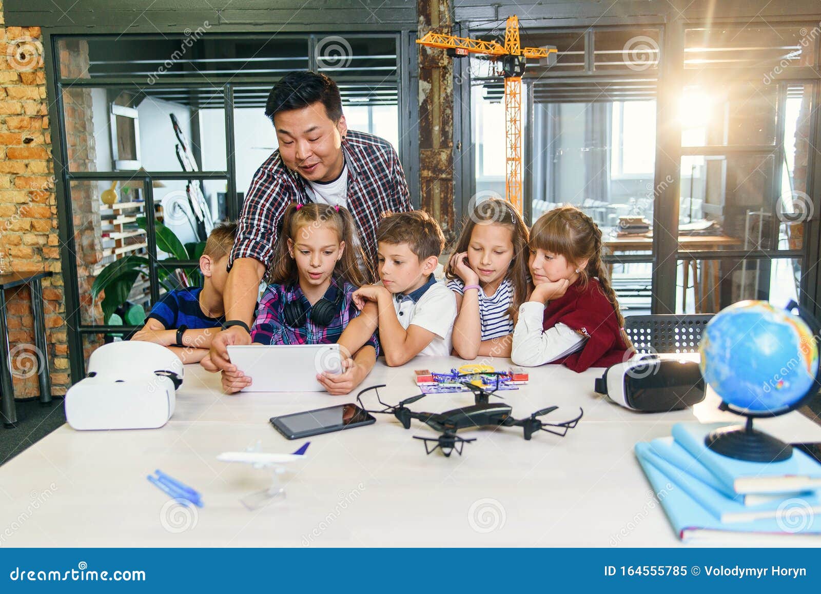 Asian Teacher Works with Five Young Pupils Using Digital Devices in ...