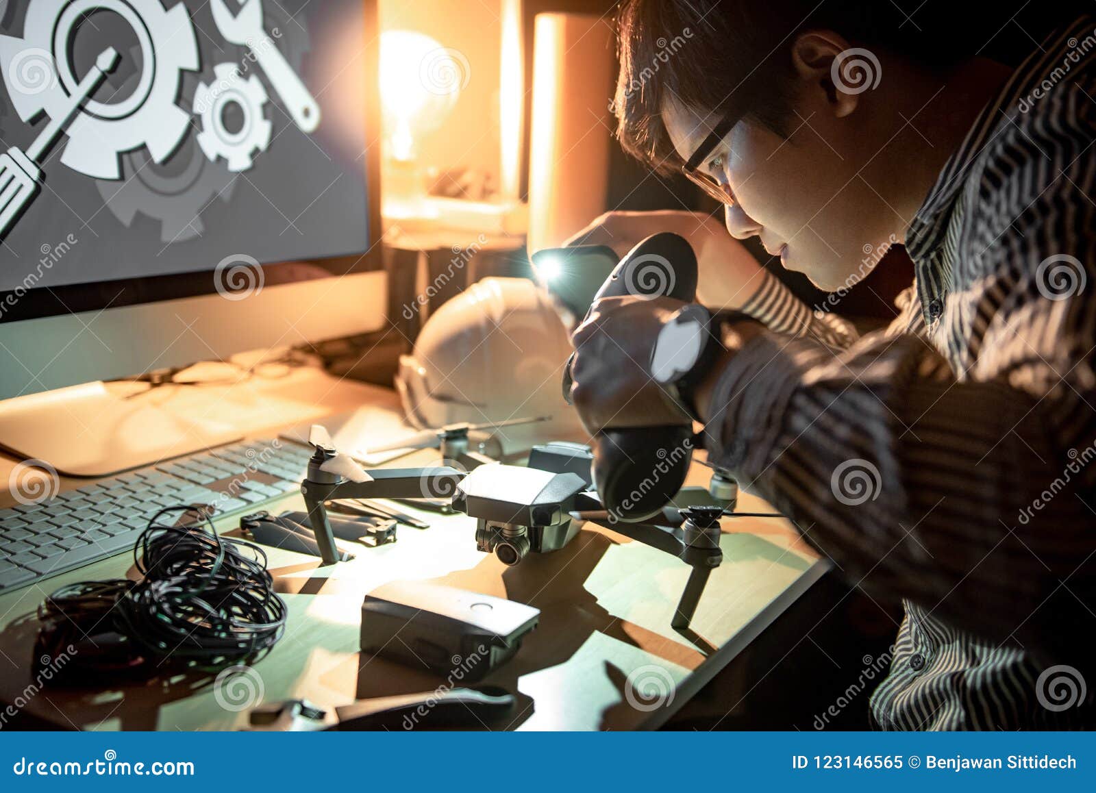 Asian Technical Engineer Using Electric Screwdriver for Repairing Drone ...