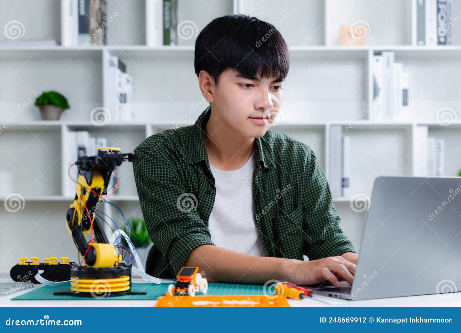 Asian Teenager Constructing Robot Arm Homework Project with Laptop in ...