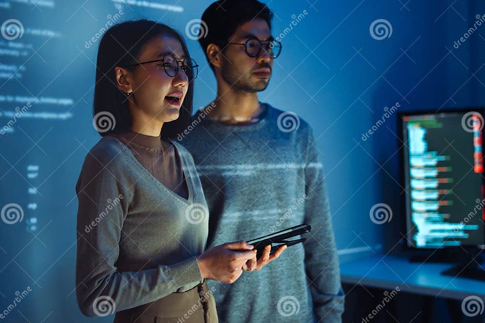 Asian Two Software Developers Engaged in Collaborative Coding Session, with Code Projected Onto ...