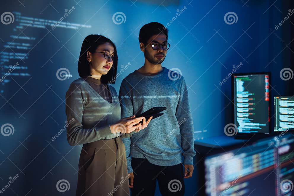 Asian Two Software Developers Engaged in Collaborative Coding Session, with Code Projected Onto ...