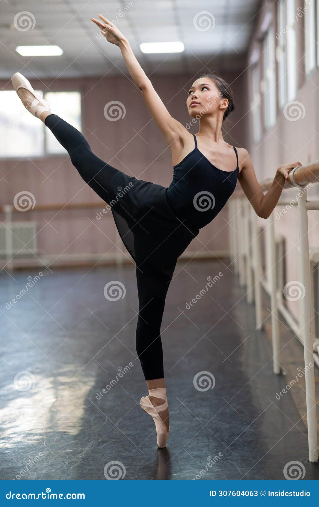 An Asian Woman Dances in a Ballet Class at the Barre. Stock Image ...