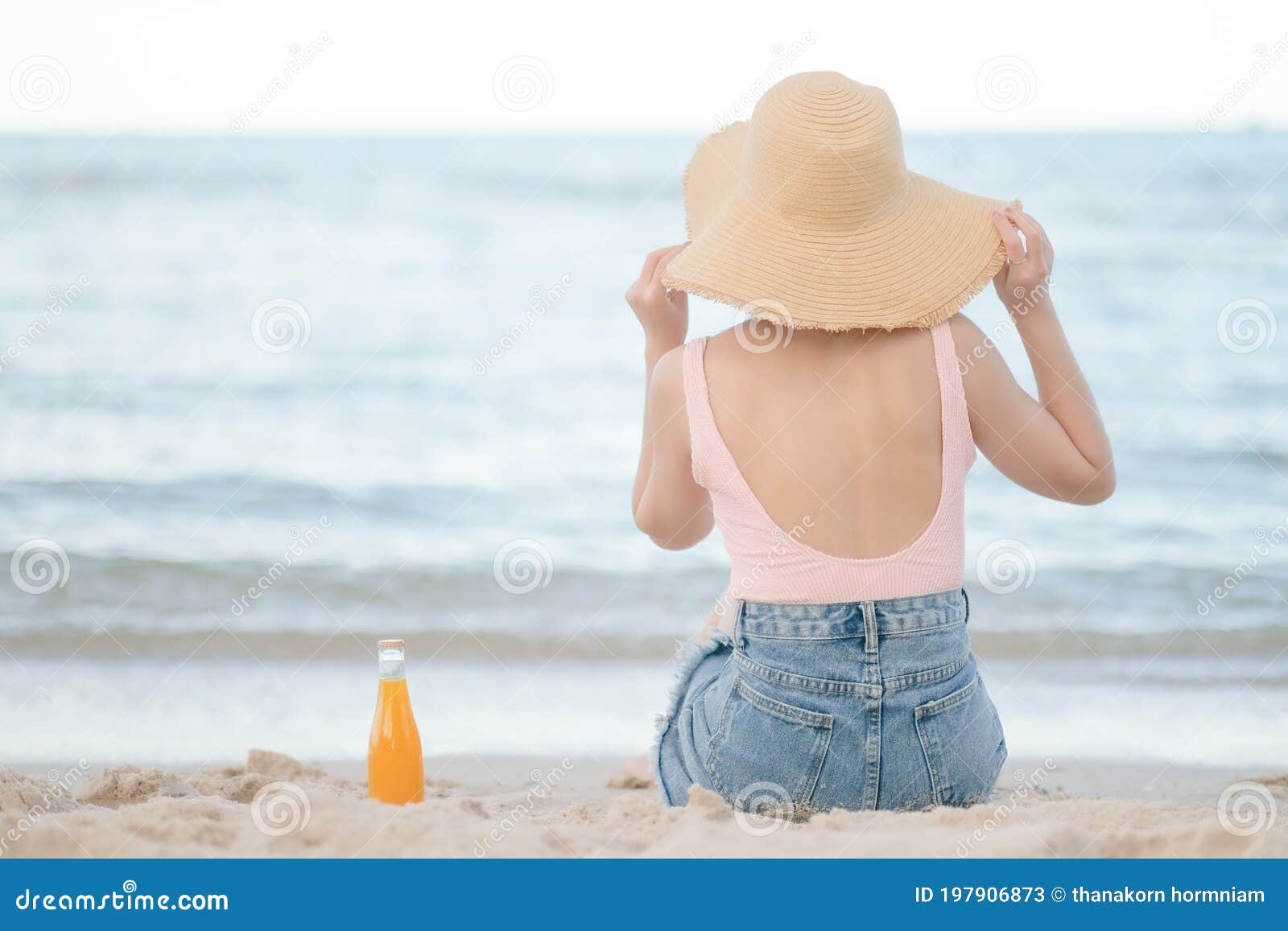 Asian Woman With Pink Swimsuit And Straw Hat On The Beach Stock Image