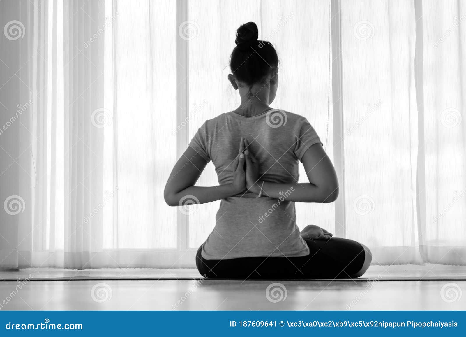 Asian Woman Practicing Yoga With Namaste Behind The Back Sitting In