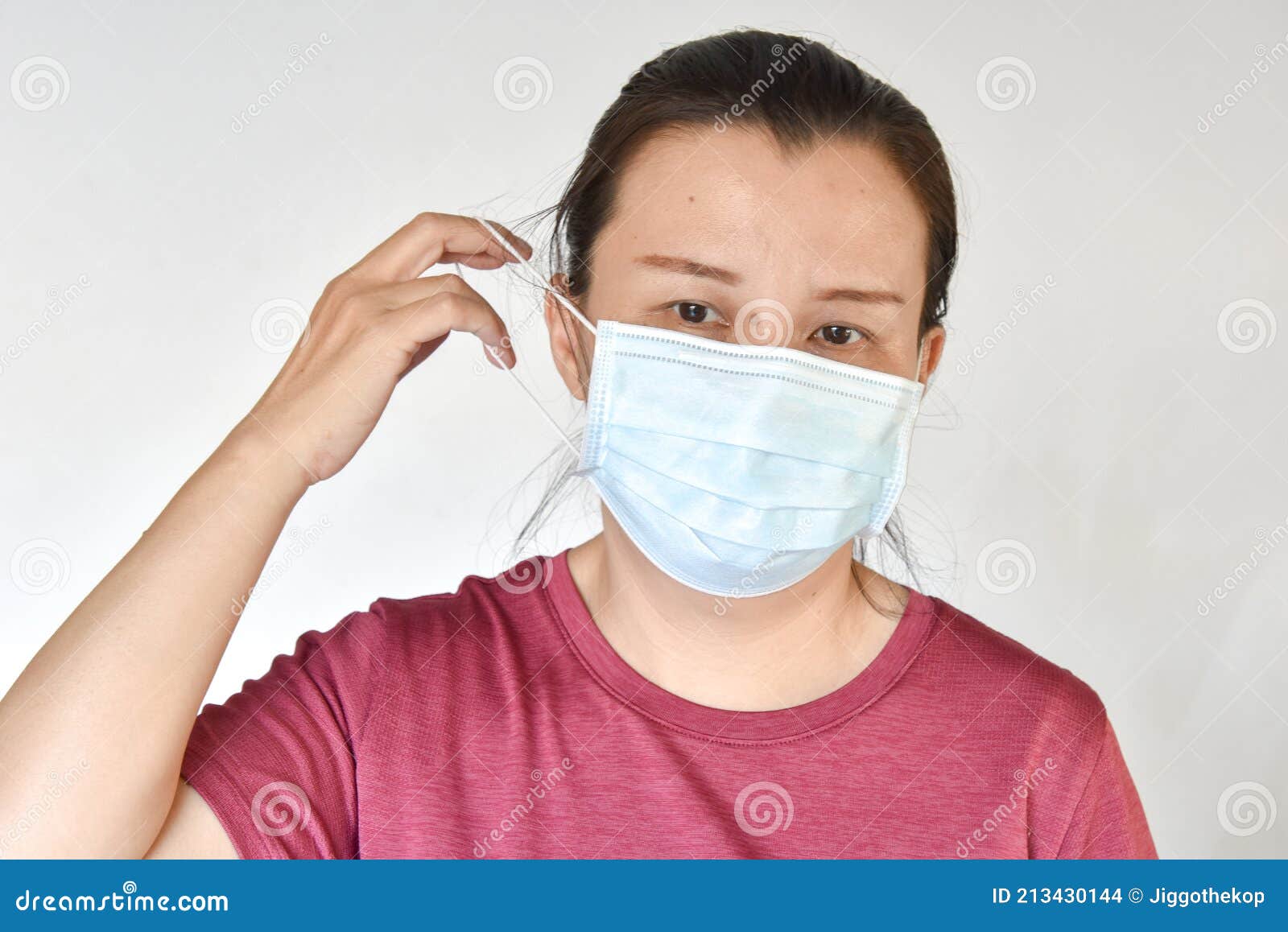 Asian Woman Removing a Mask from Her Face Stock Photo - Image of ...