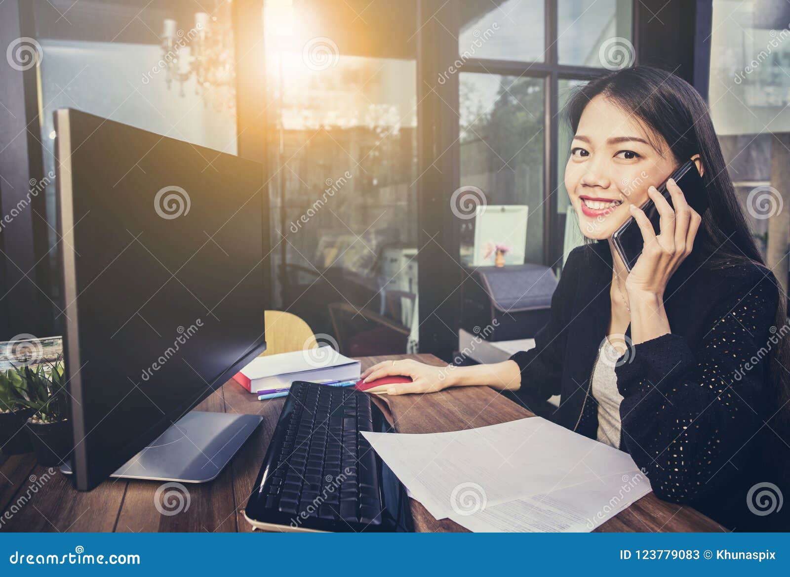 Asian Working Woman Using Computer in Home Office and Talking O Stock ...