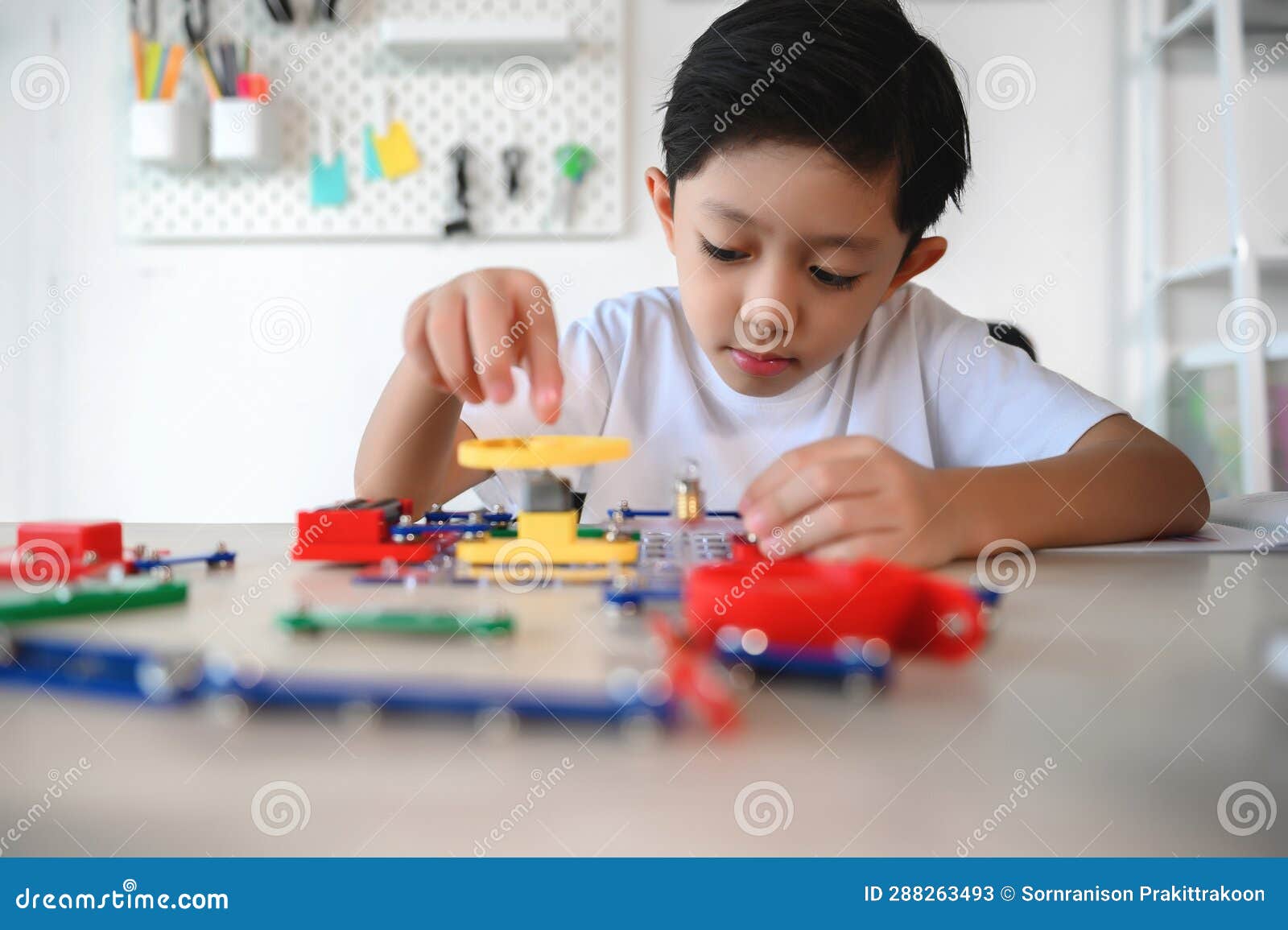 Asian Young Child Concentrate and Focus on Connecting Electronic Constructor. Learning and ...