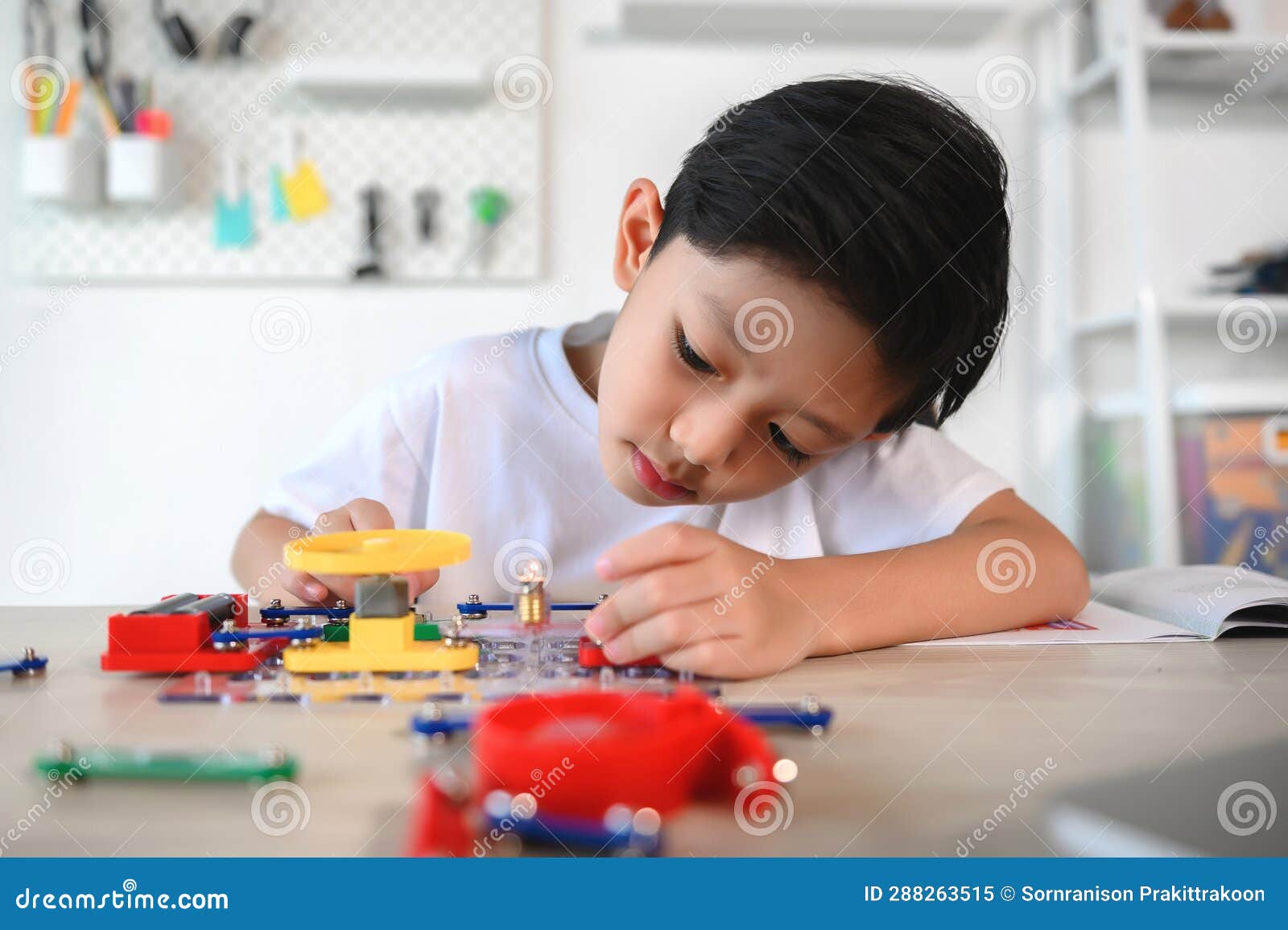 Asian Young Child Concentrate and Focus on Connecting Electronic Constructor. Learning and ...