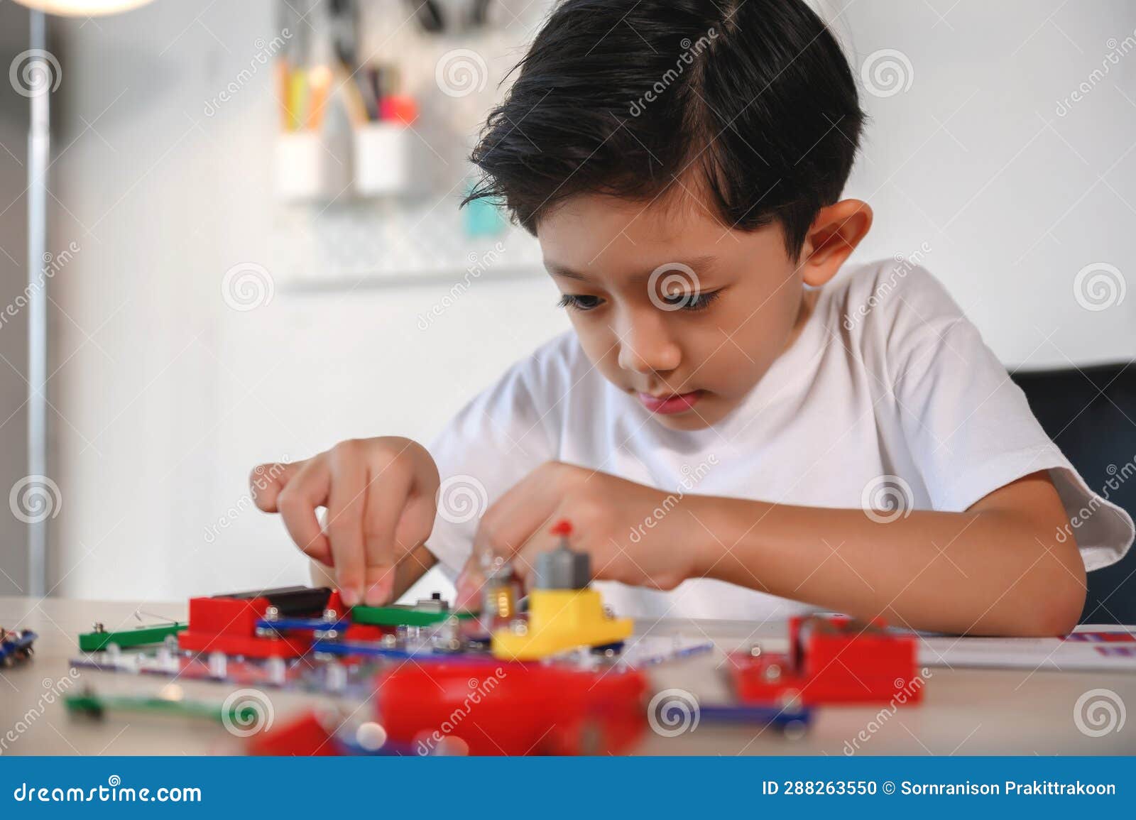 Asian Young Child Concentrate and Focus on Connecting Electronic Constructor. Learning and ...