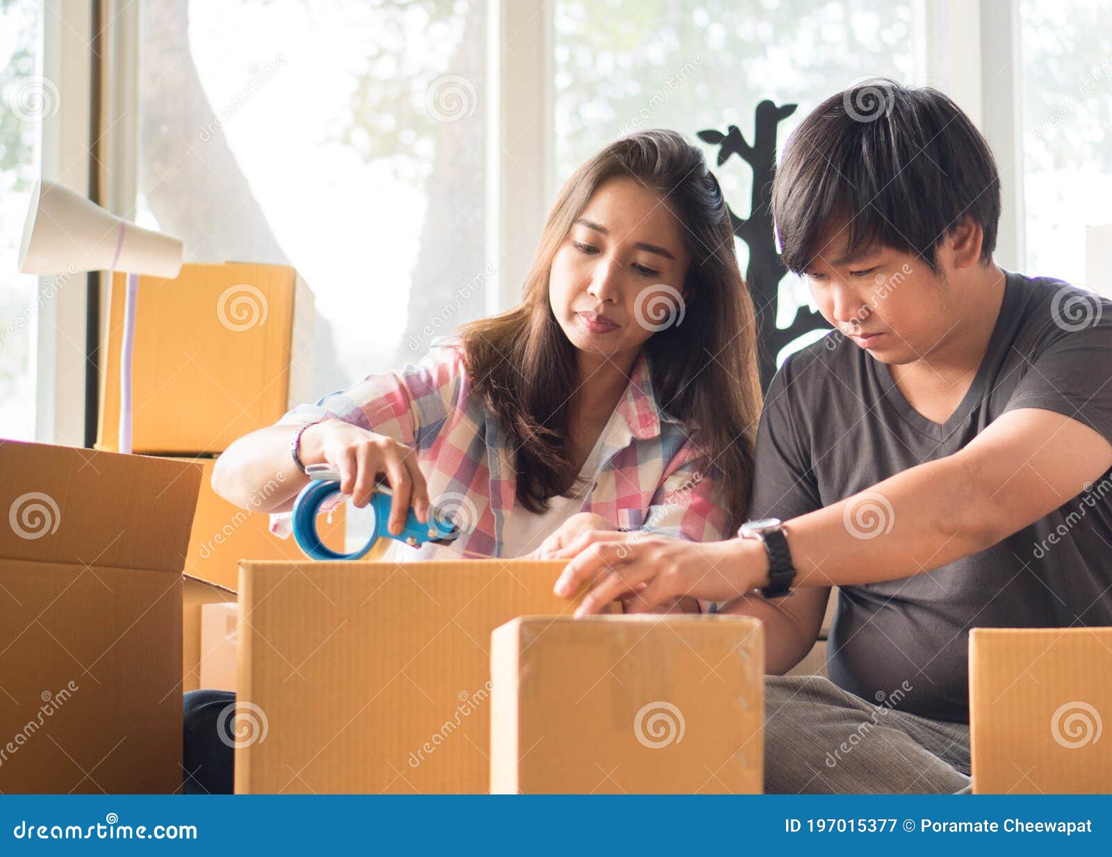 Asian Young Couple Unpack Cardboard Box After Moving In New House Stock