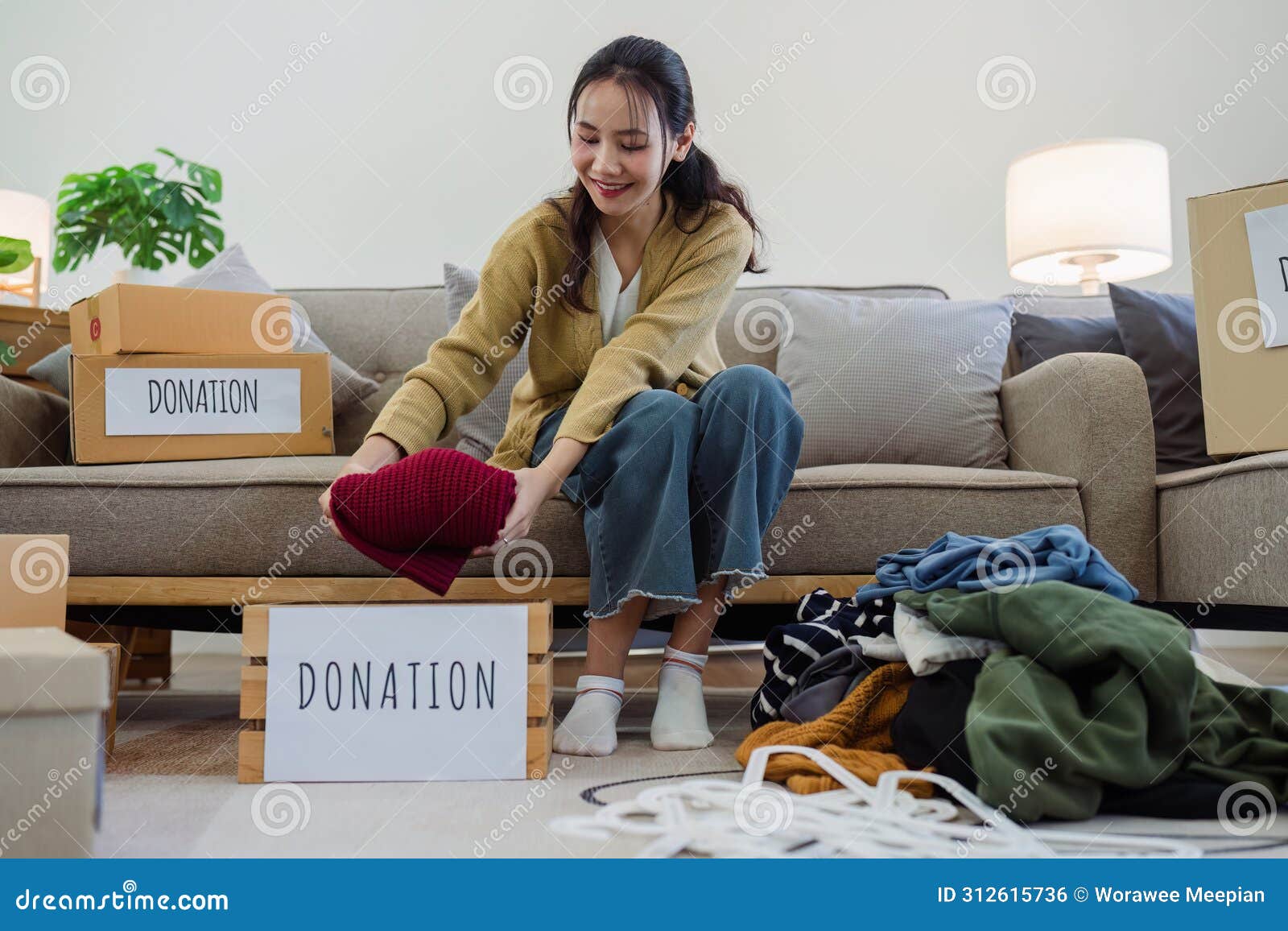 Asian Young Woman Packing Clothes at Home, Putting on Stuff into Donate ...