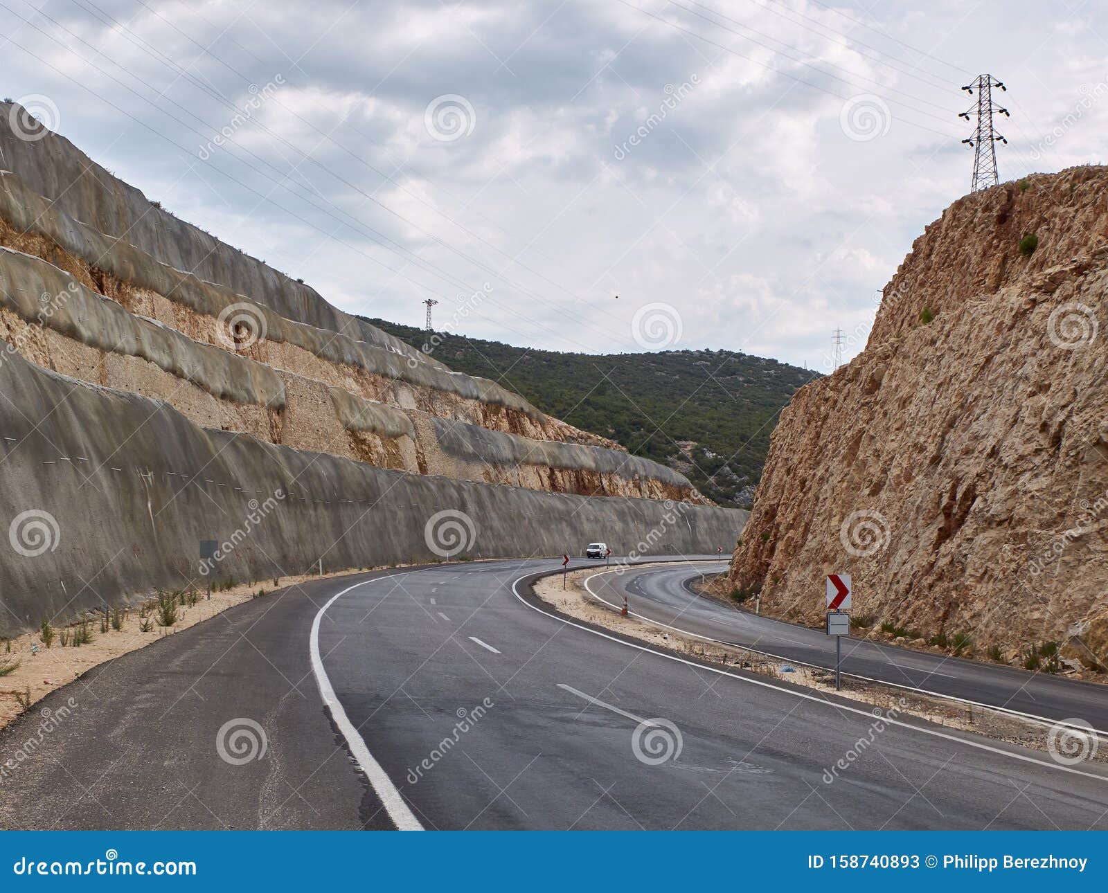 Asphalt Road Curves between Two Rock Cliffs with Openwork Power Line ...